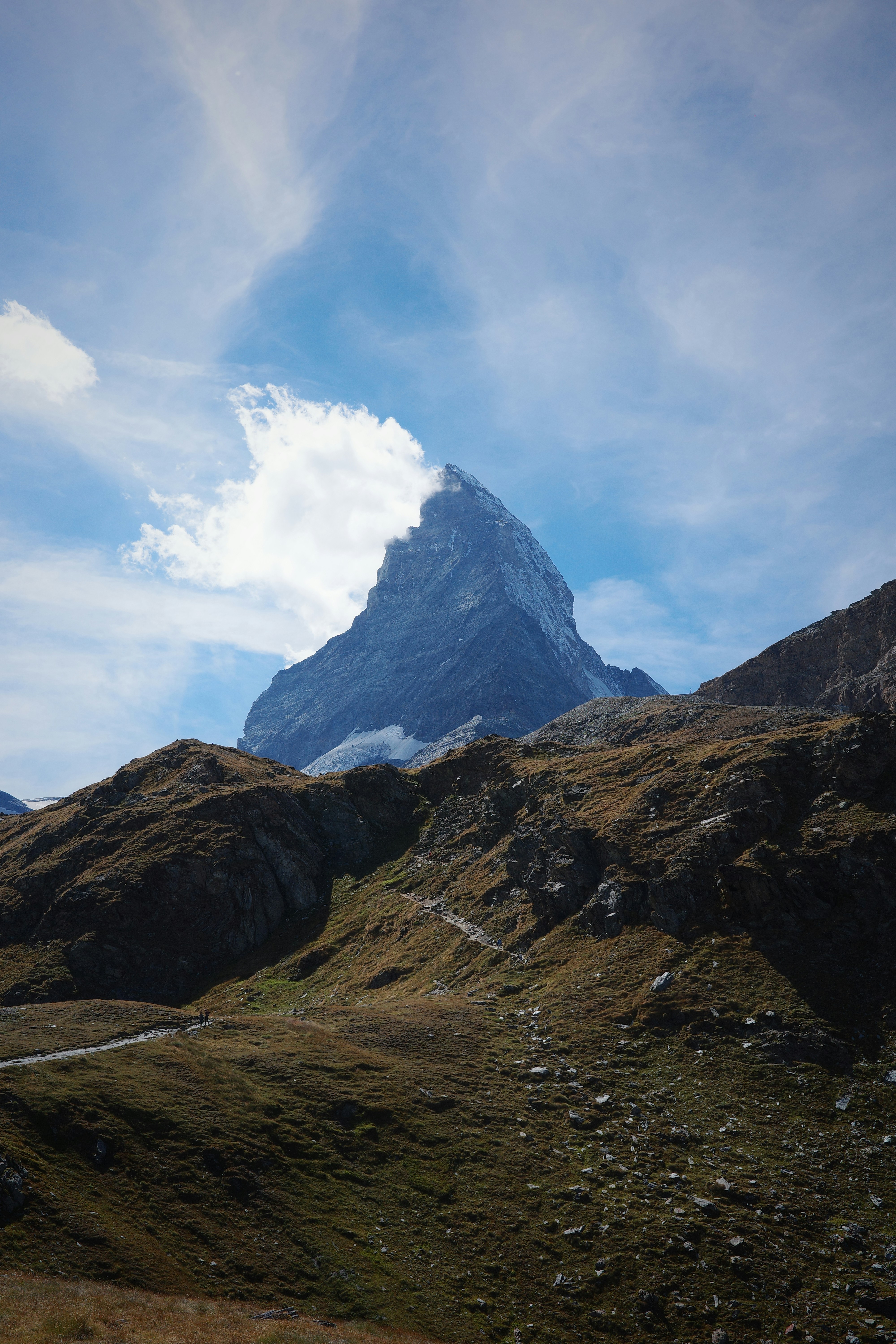 Trail to the Alpine Pinnacle: A Rugged Approach Under a Clear Sky