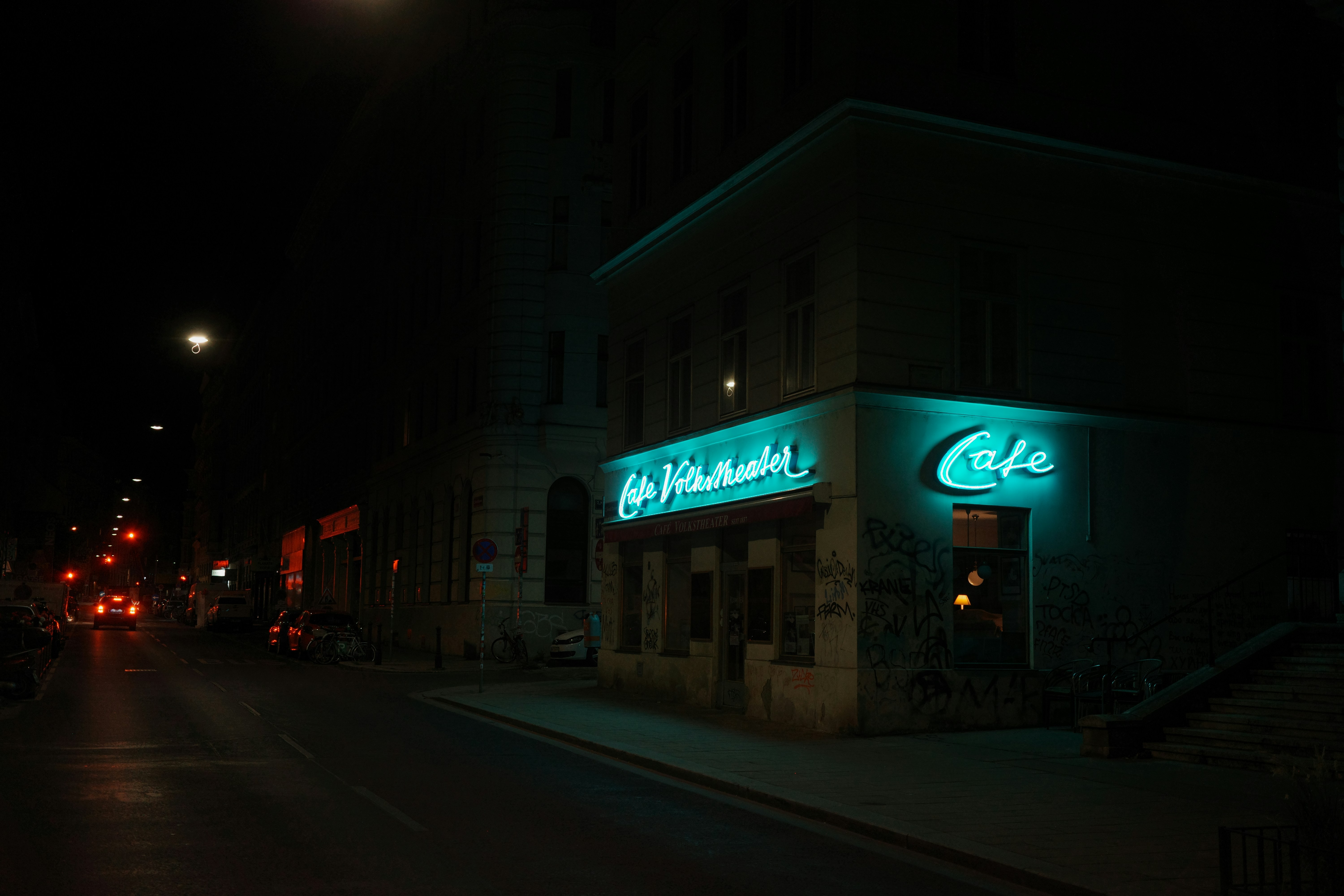 A cafe glows with neon lights at night.