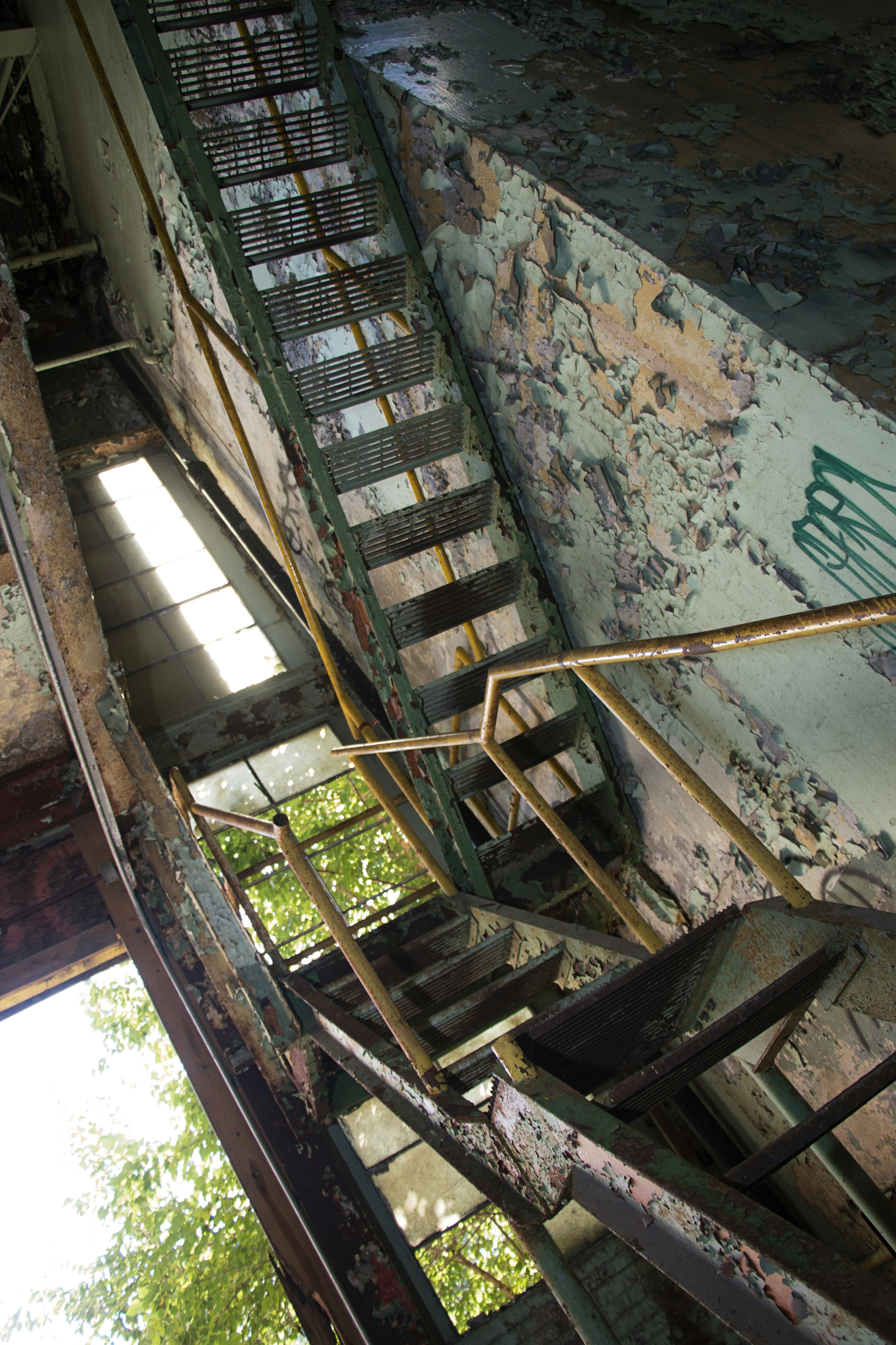 Abandoned Staircase: Rust, Peeling Paint, and Dappled Light