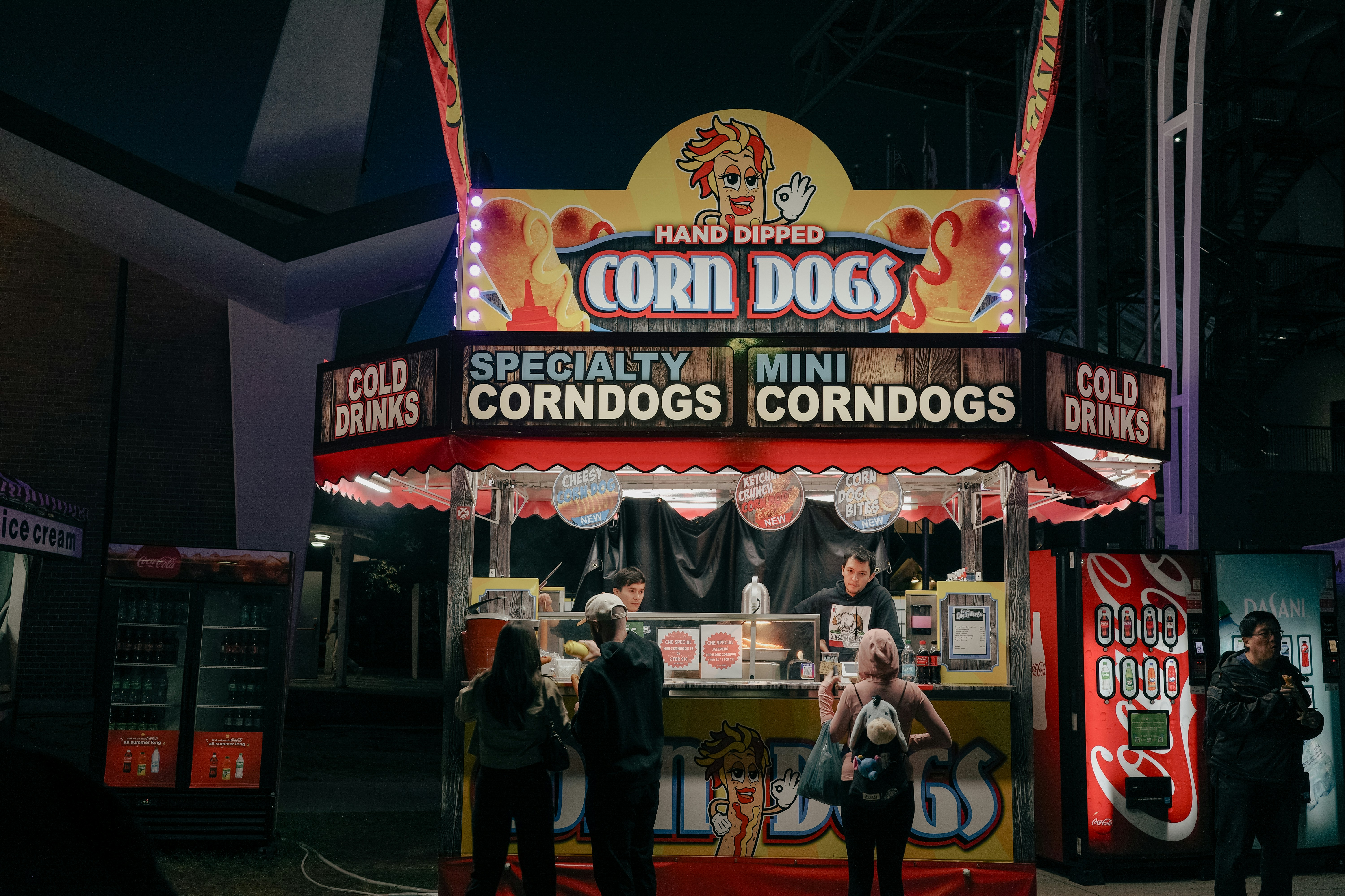 Neon Night at the Corn Dog Stand: Hand-Dipped Delights Beneath Marquee Lights
