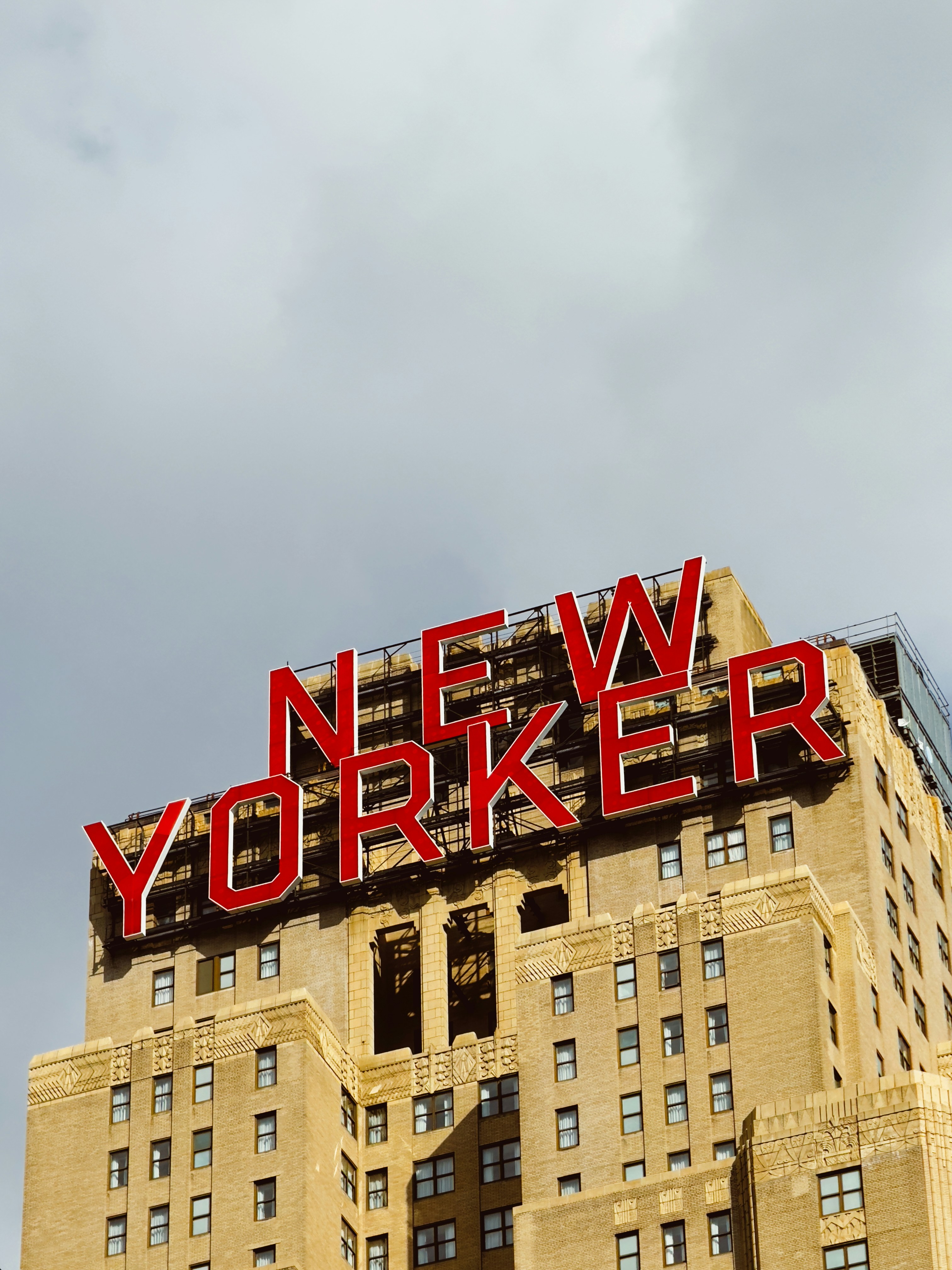 Created with RNI Films app. Profile 'Fuji Fortia SP v.2' | New yorker hotel sign against cloudy sky