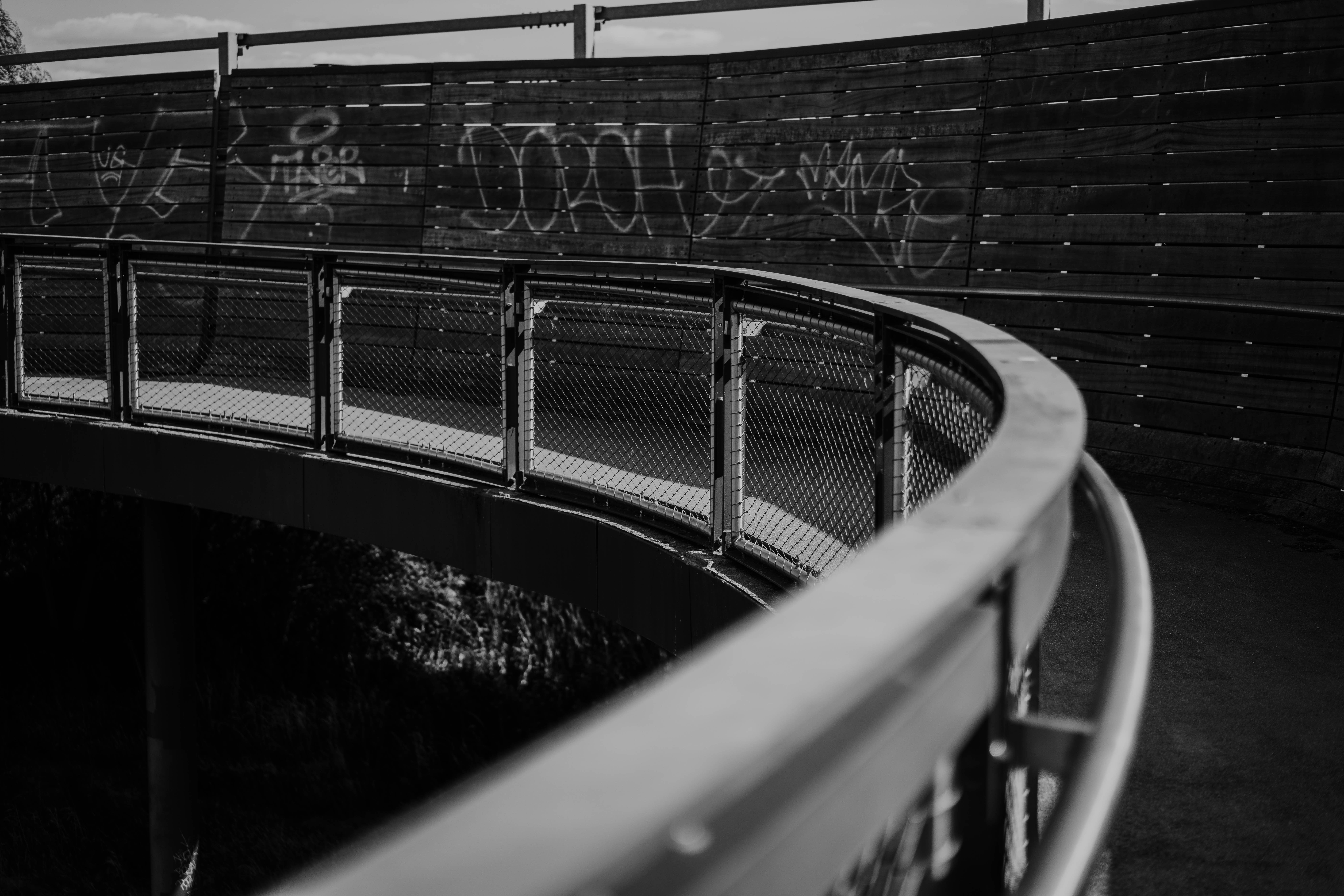 Curved Railing Over Graffiti-Walled Darkness