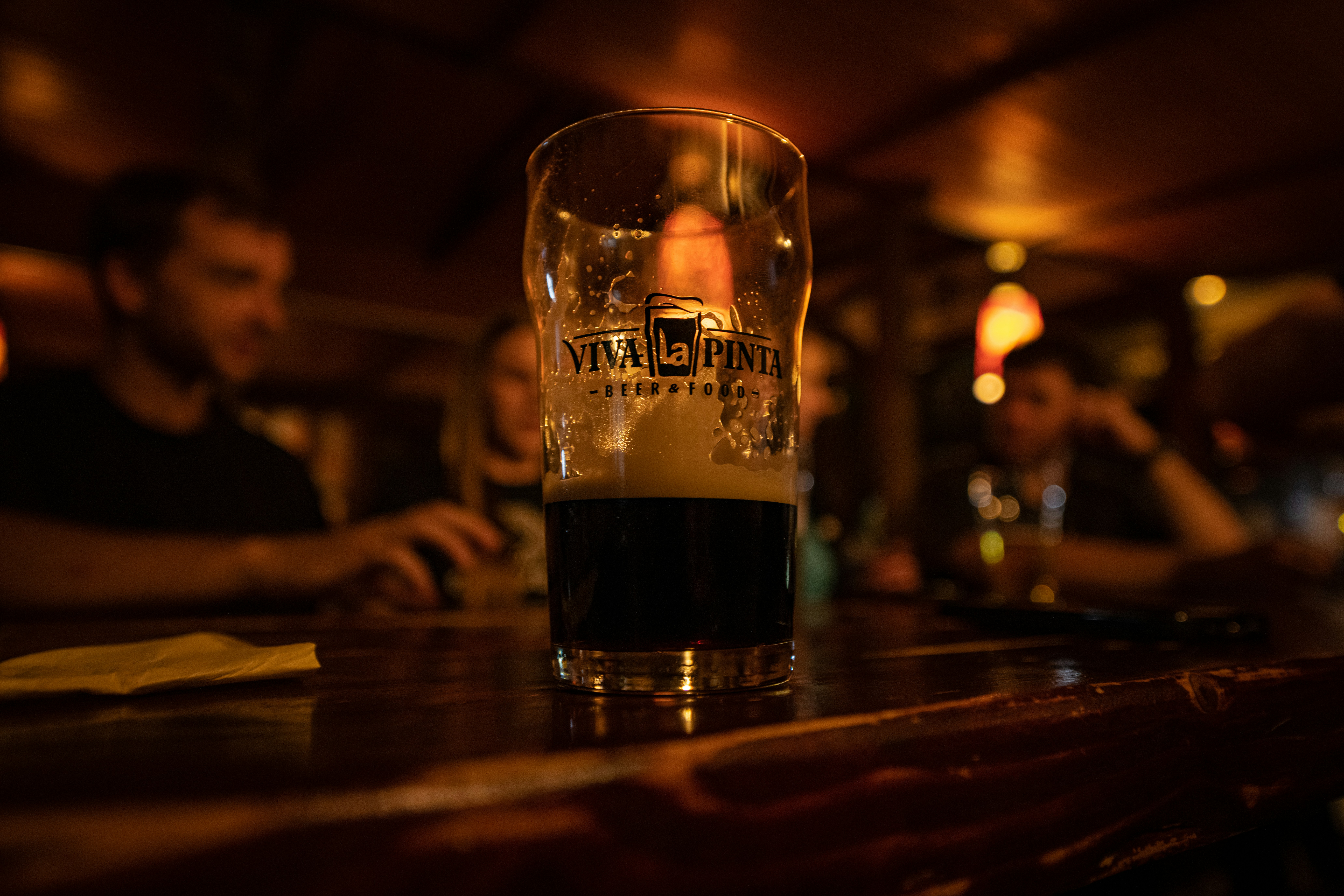 Glass of dark beer on a bar counter