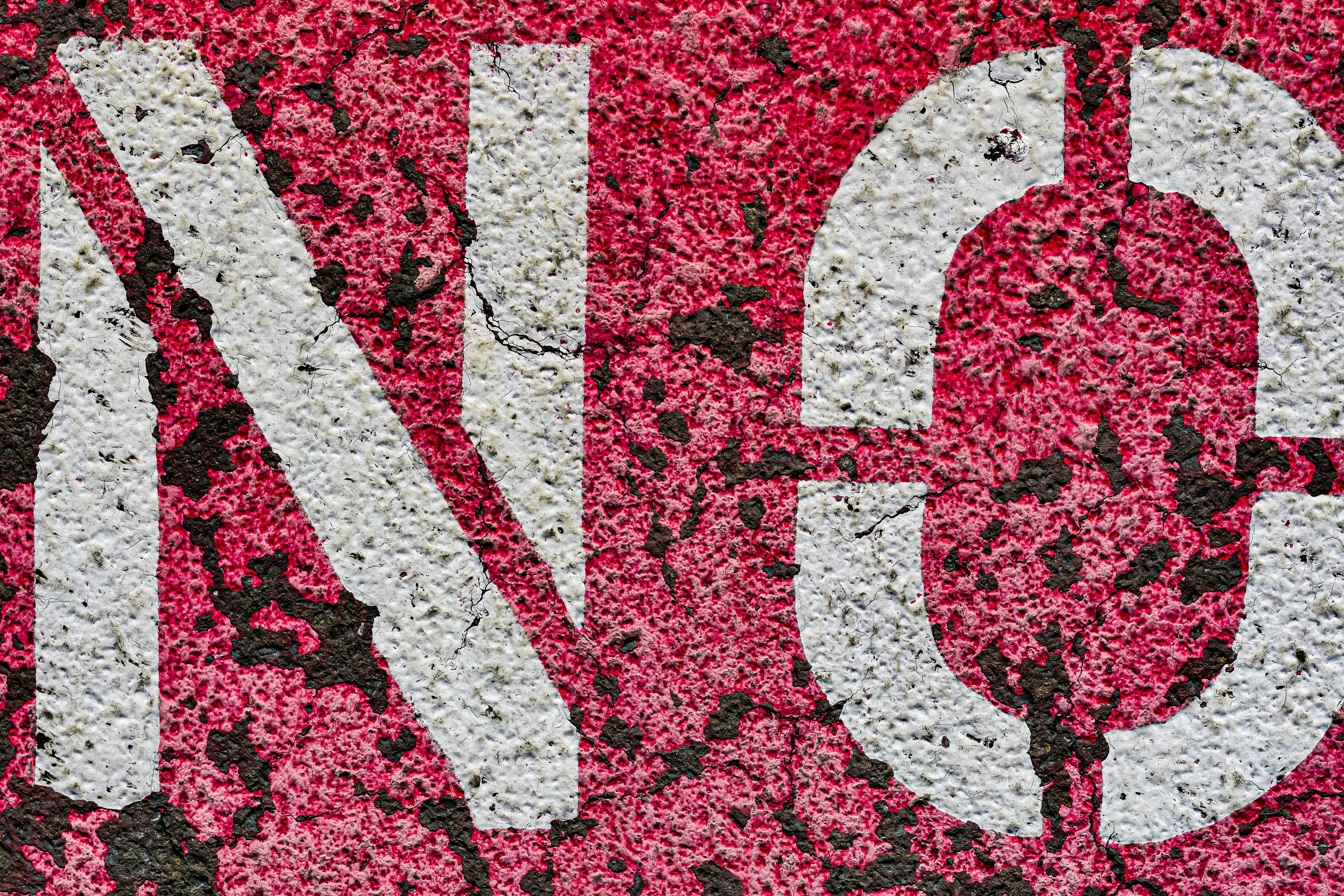 NO as a road marking | White letters spelling no on red background