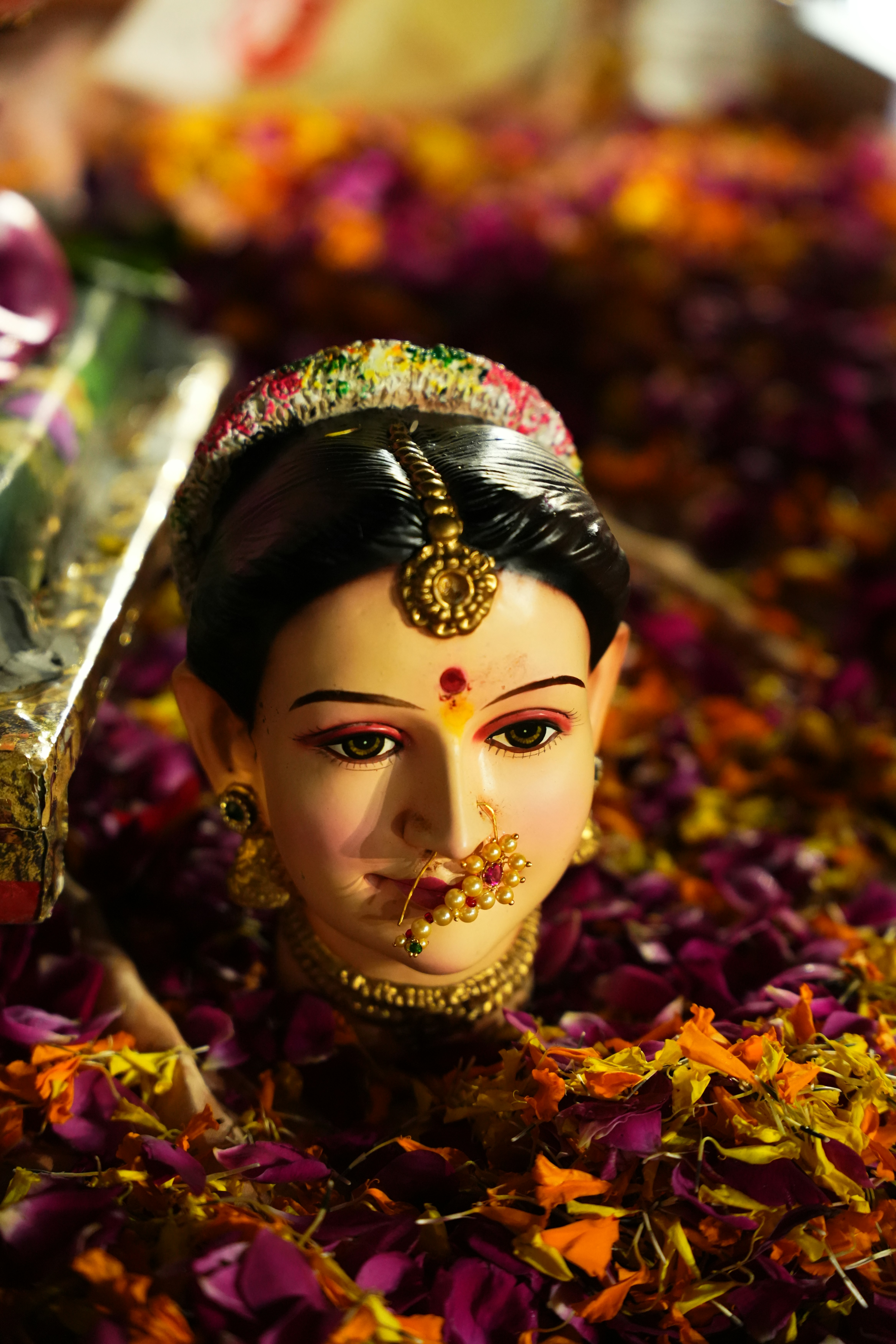 Head Sculpture Amid Petals: A Sacred Still Life
