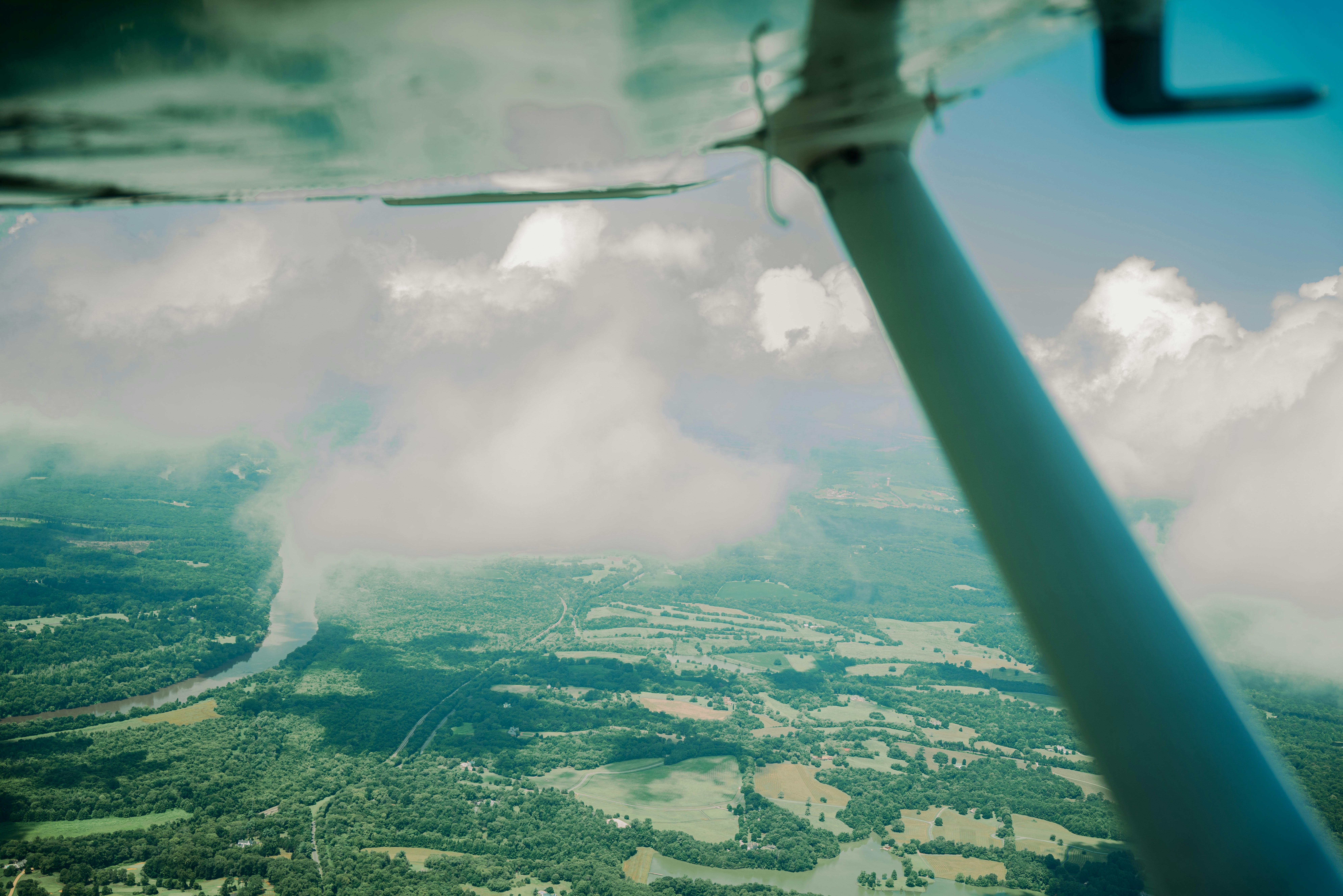 Aerial Over Green Patchwork: Cloud-Soft Flight Over Farmland