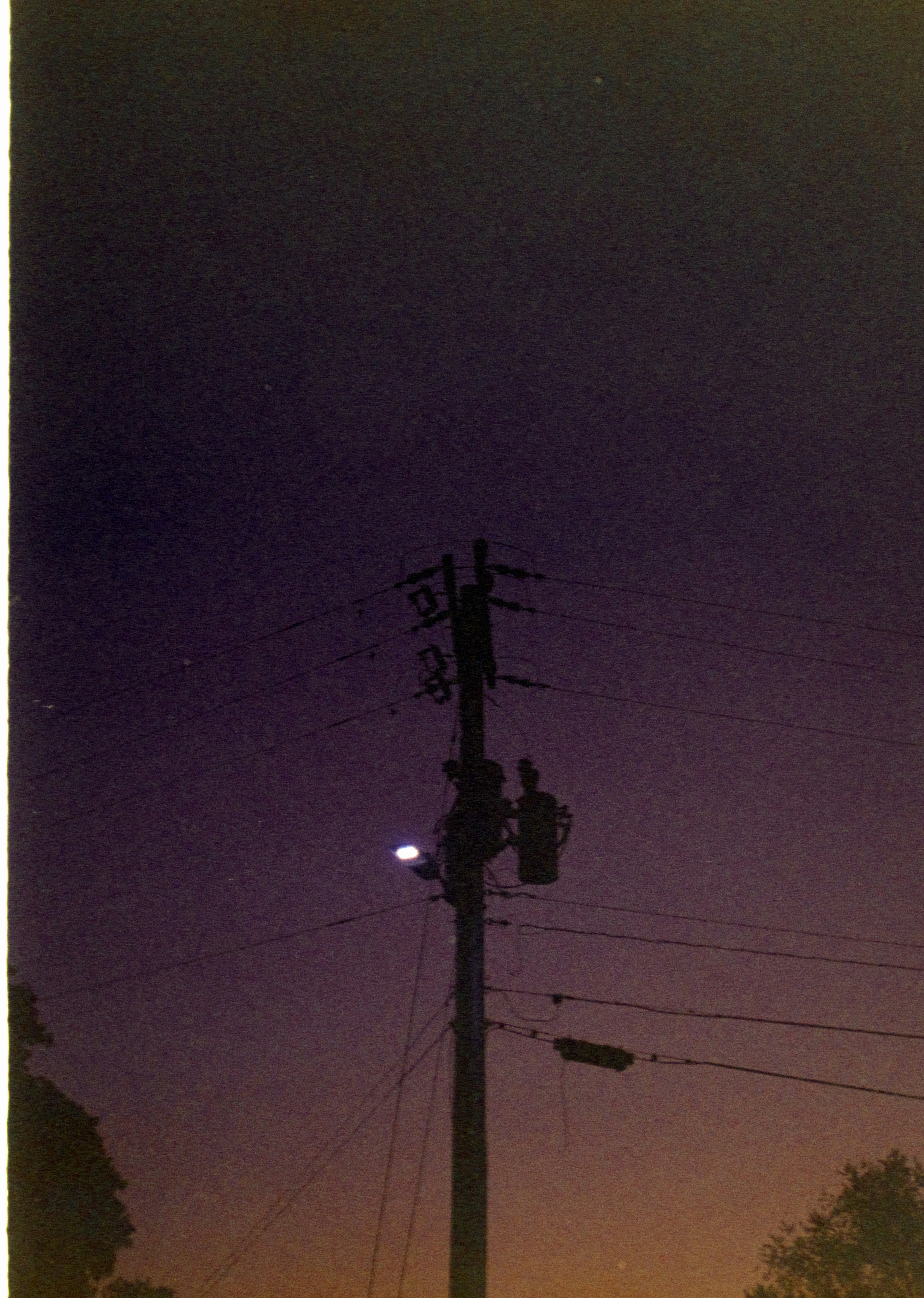 Telephone pole against a dark purple sky