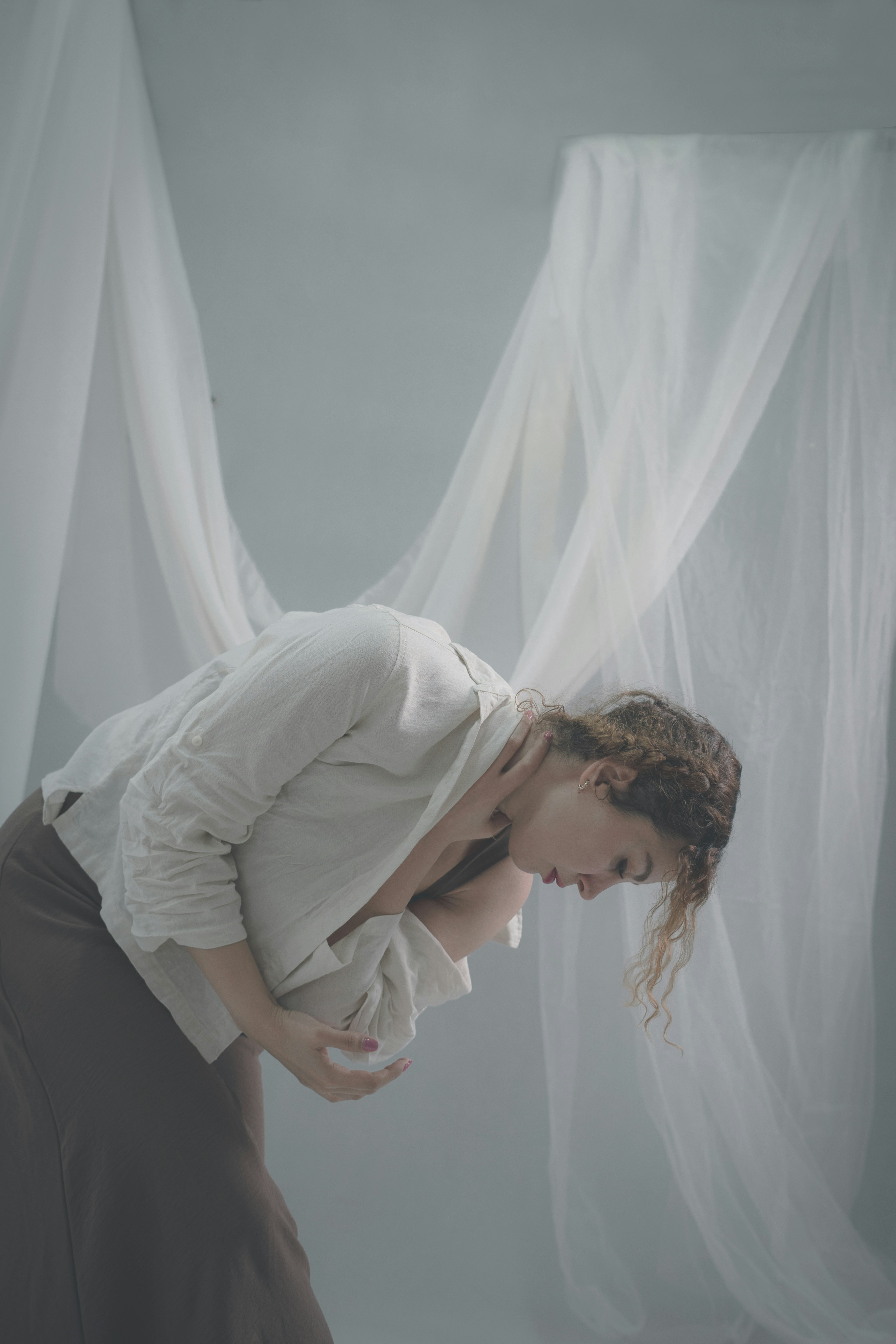 Woman in white shirt and brown skirt with draped fabric