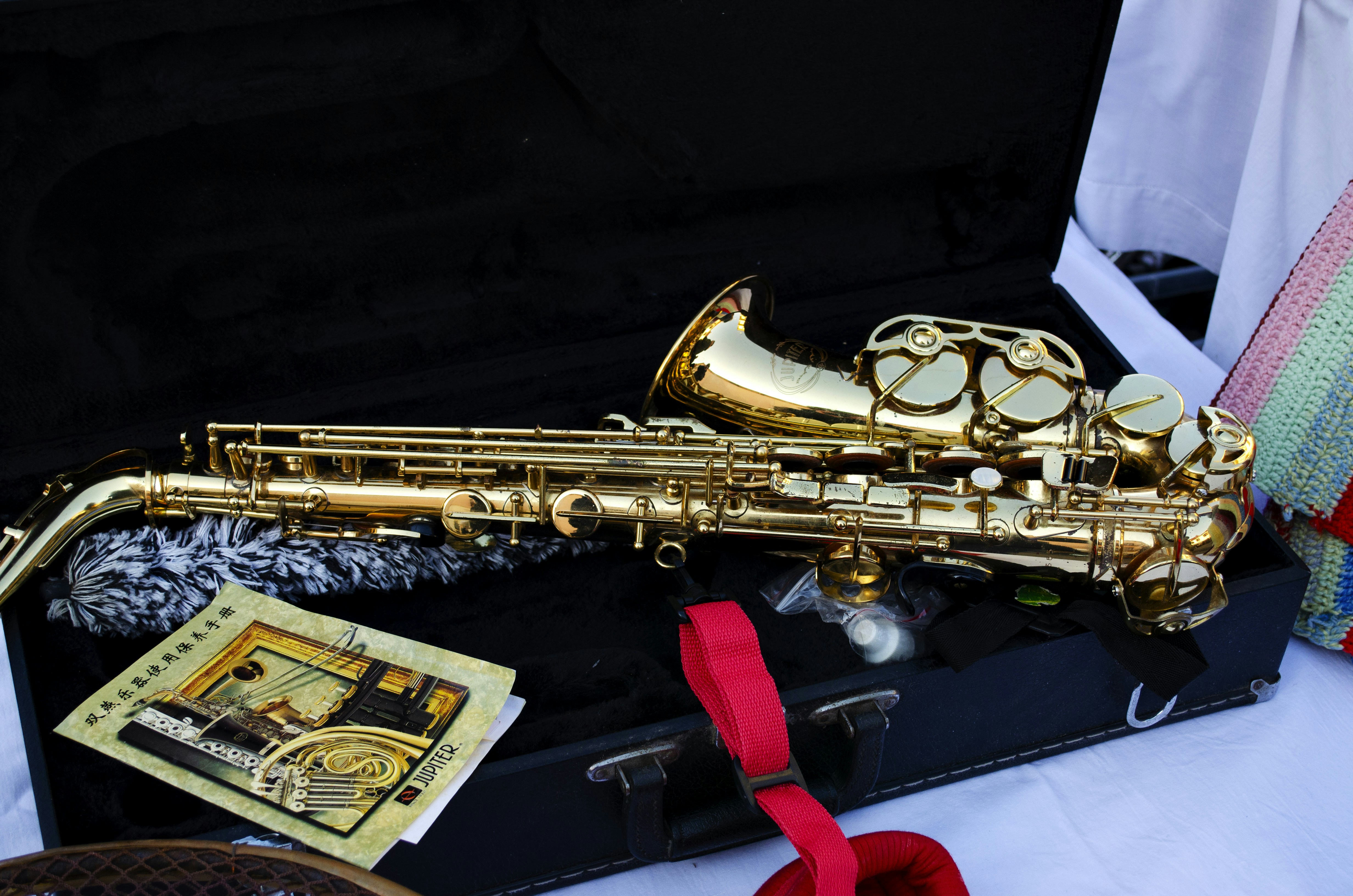A shiny brass saxophone rests in its case.