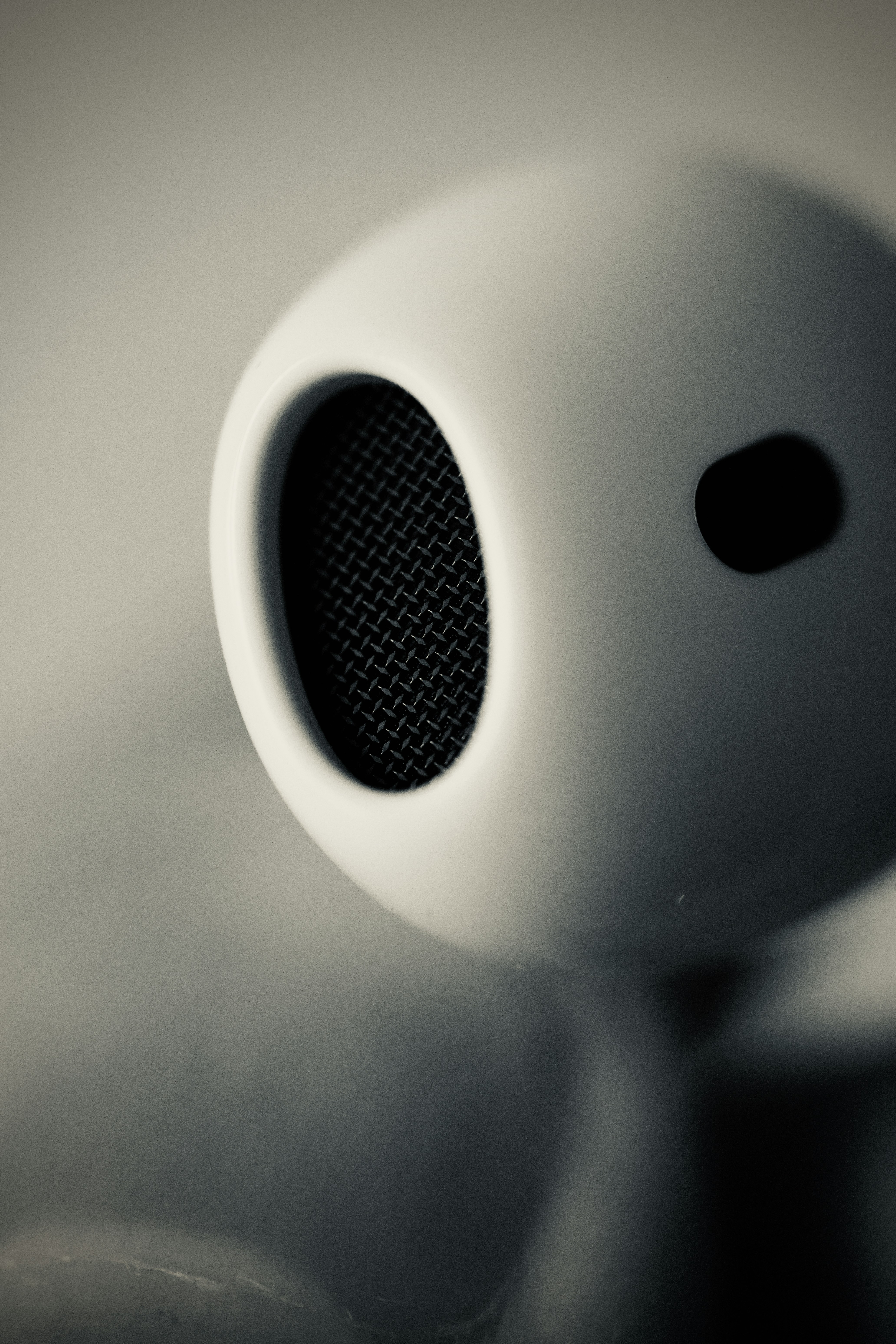 Close-up of a white earbud with mesh detail