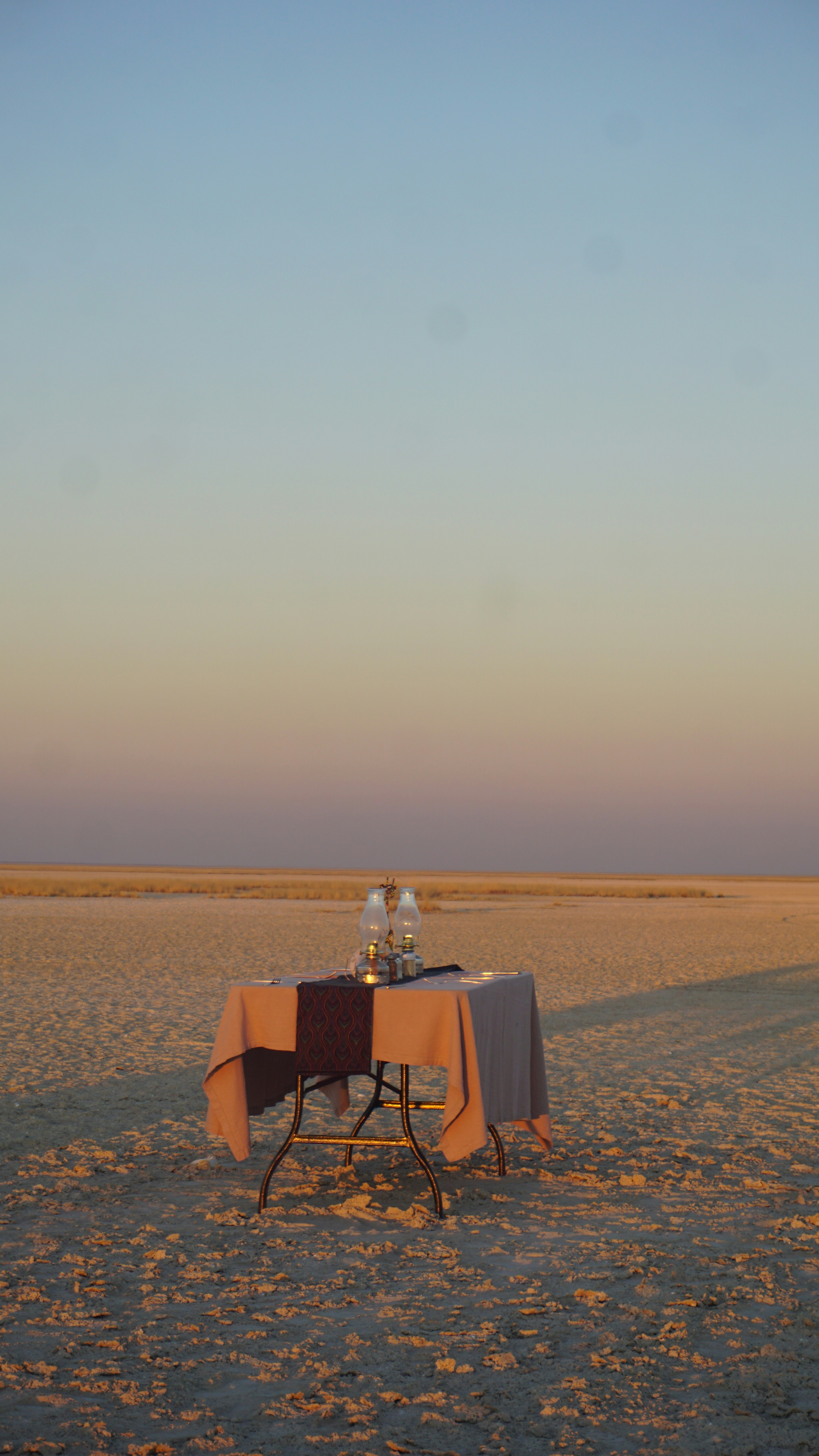 A table set for two in a vast, empty landscape.