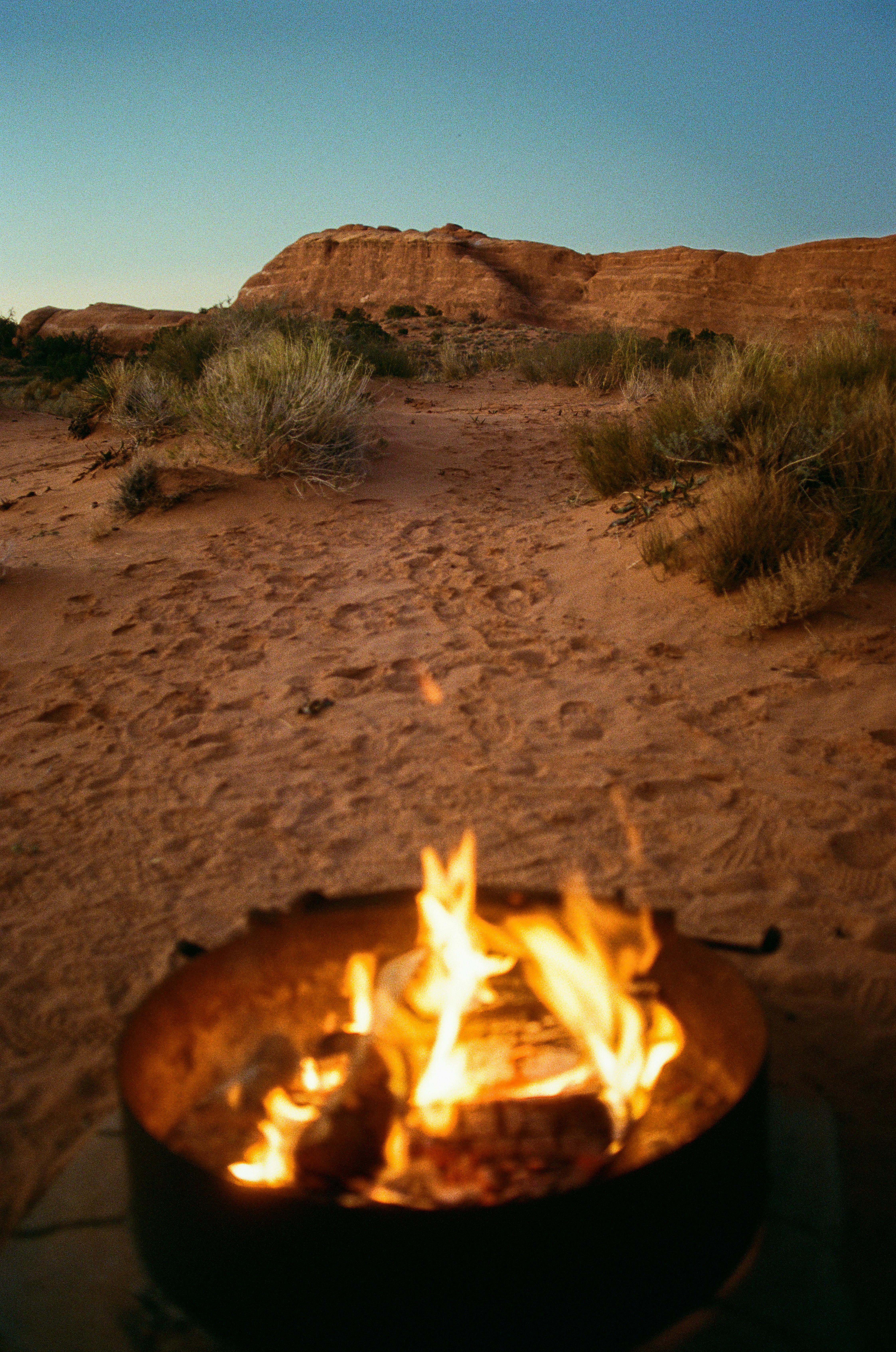 Canyon Nights at Arches National Park. Fall campfire campout. | Campfire burning in a desert landscape at dusk