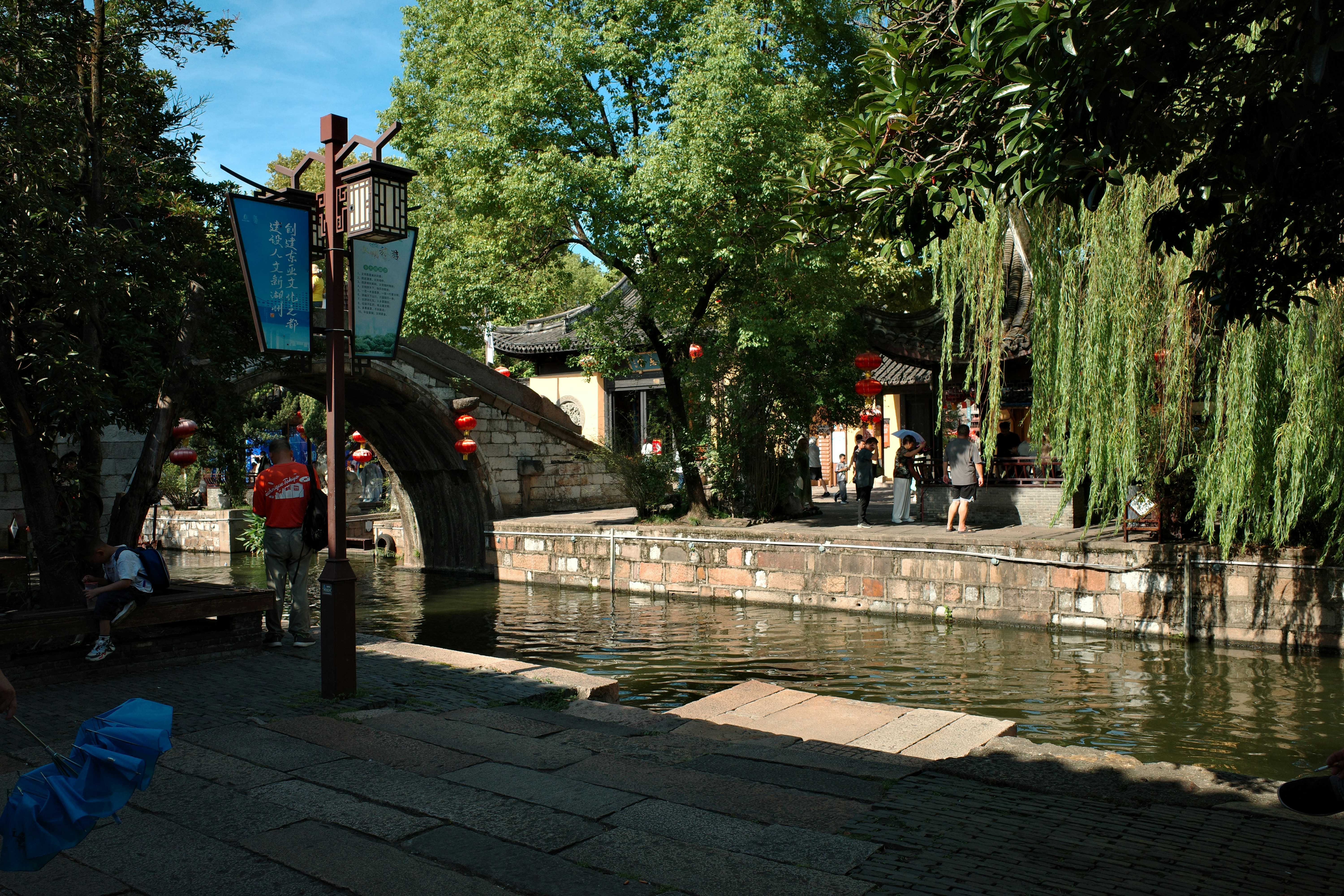 Sunlit canal and stone-arch bridge: a quiet riverside courtyard