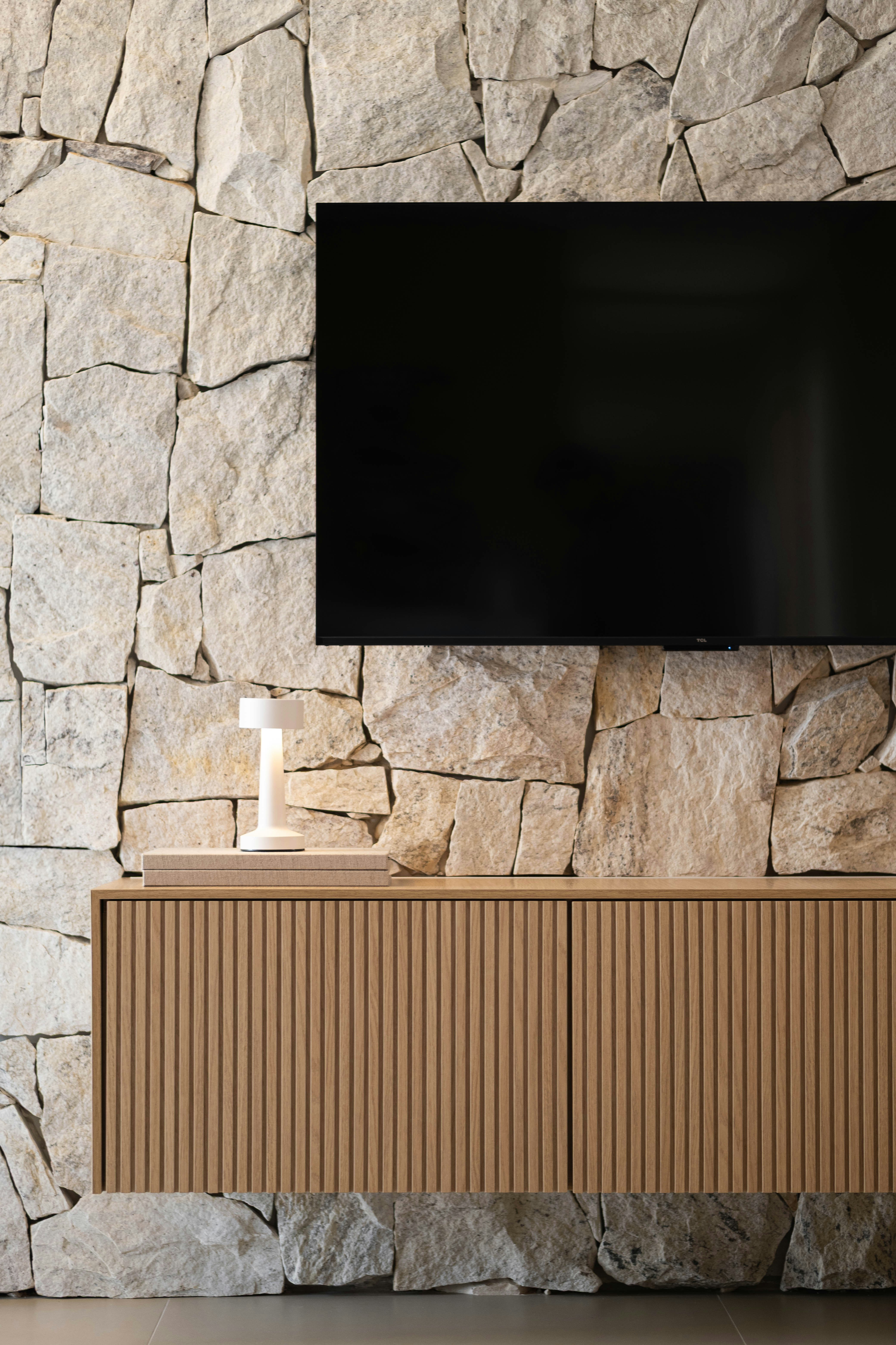 Fotografia para o Arquiteto Douglas Schultz. Projeto em Torres, RS. | Modern television mounted on a stone wall above cabinet.