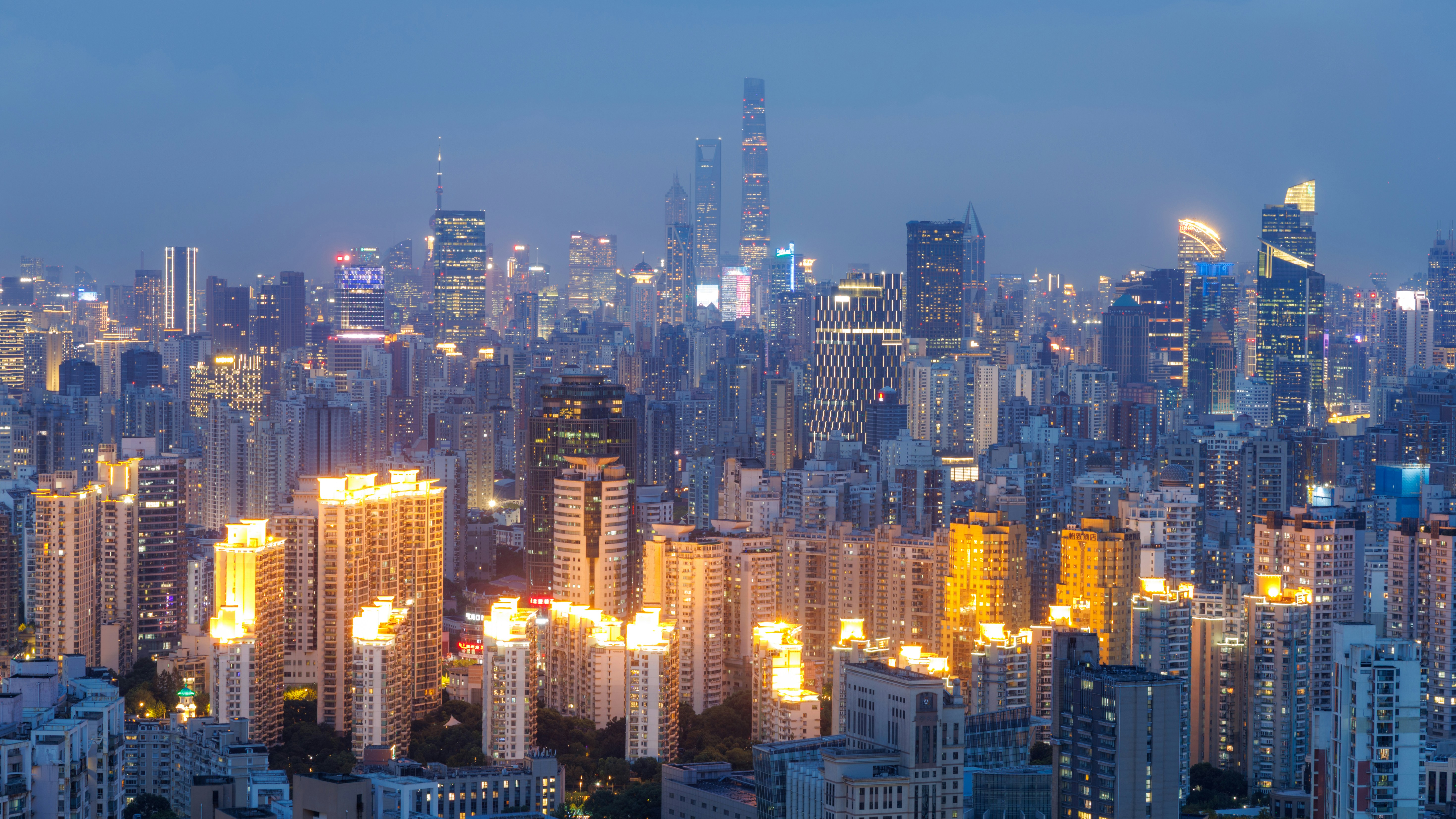 Top of Shanghai | Vibrant cityscape illuminated at dusk with glowing buildings.