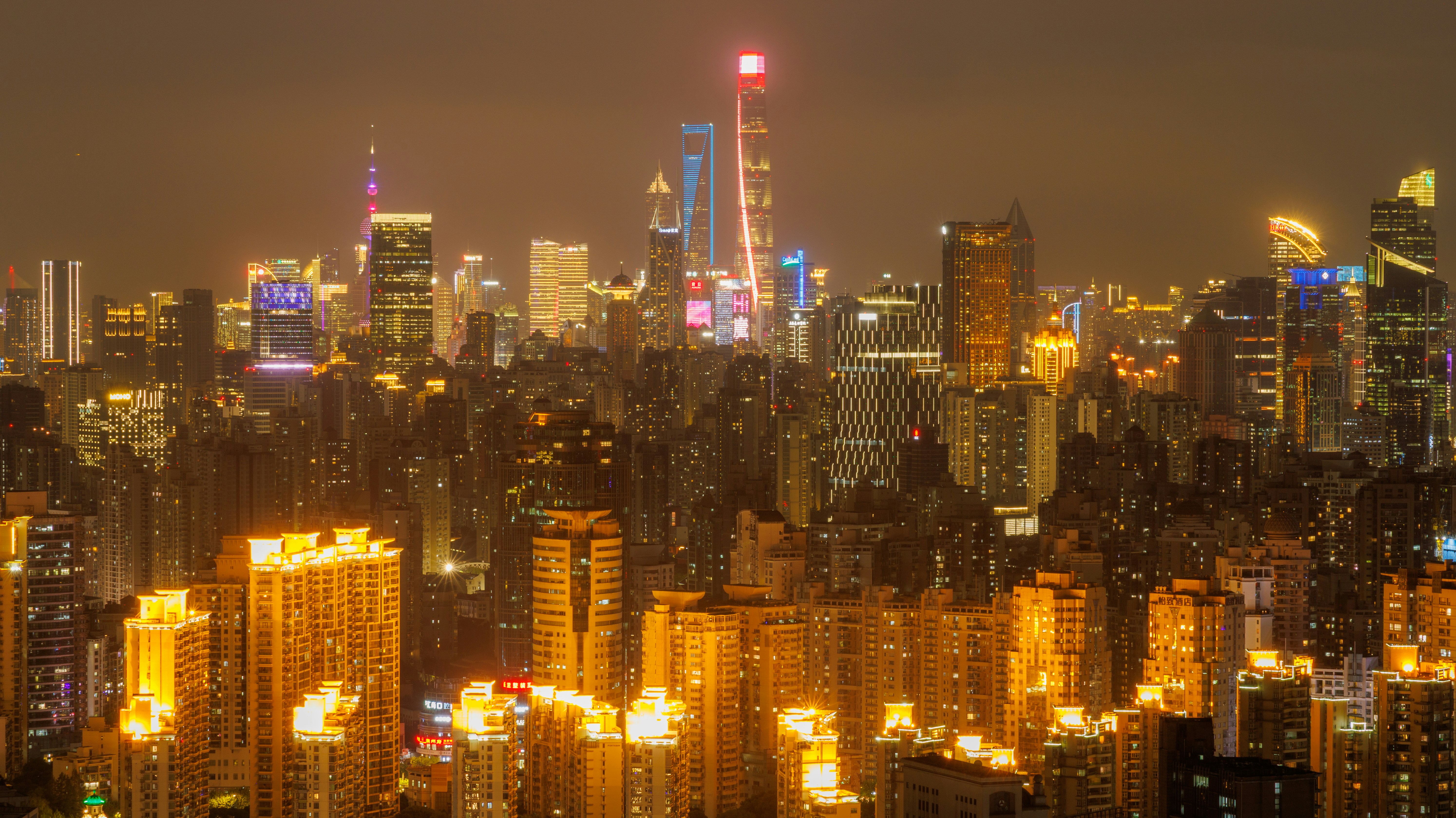 Gleaming cityscape illuminated at night with skyscrapers.