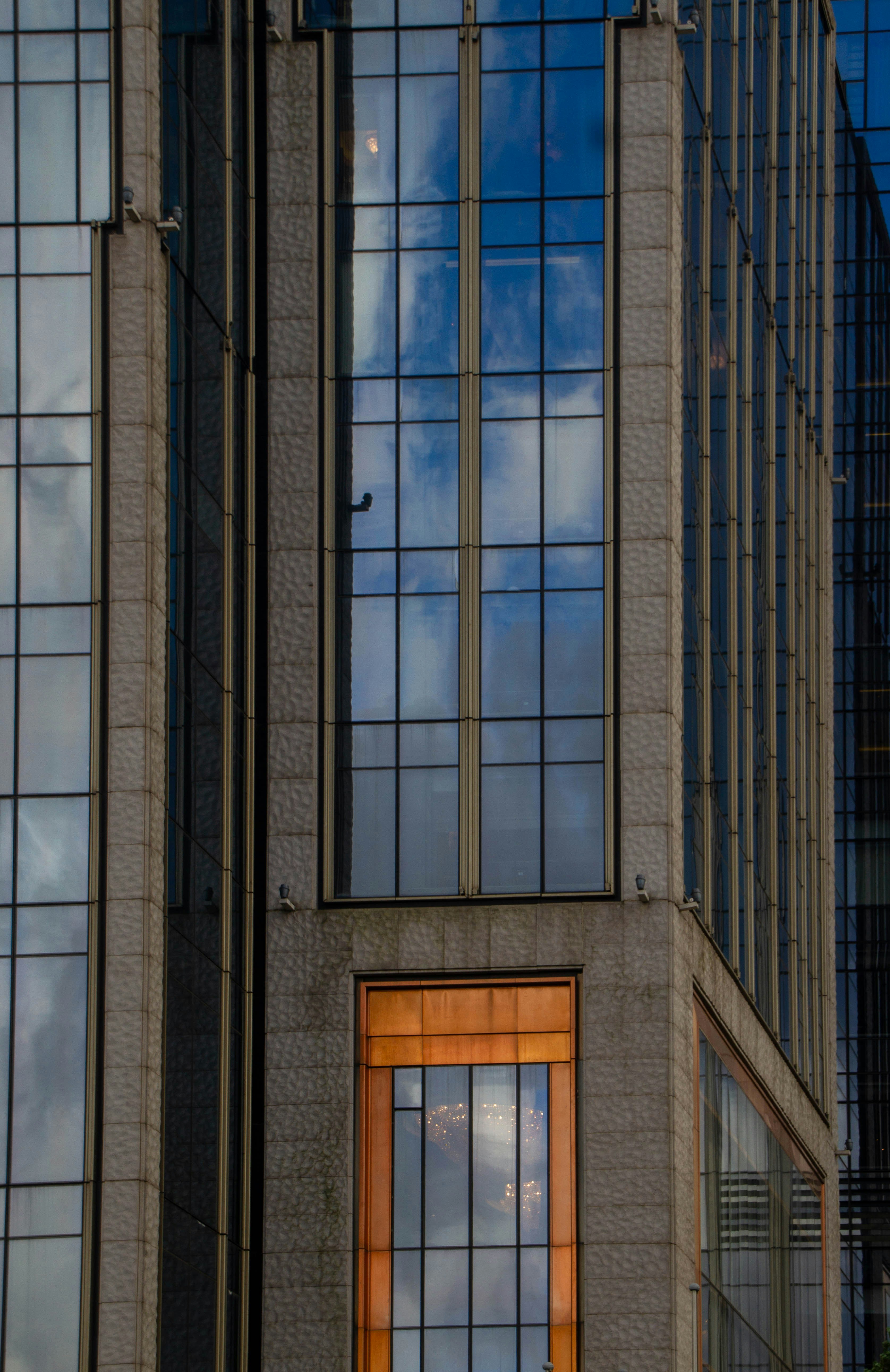 I love this | Modern skyscraper with reflective glass windows and stone facade.