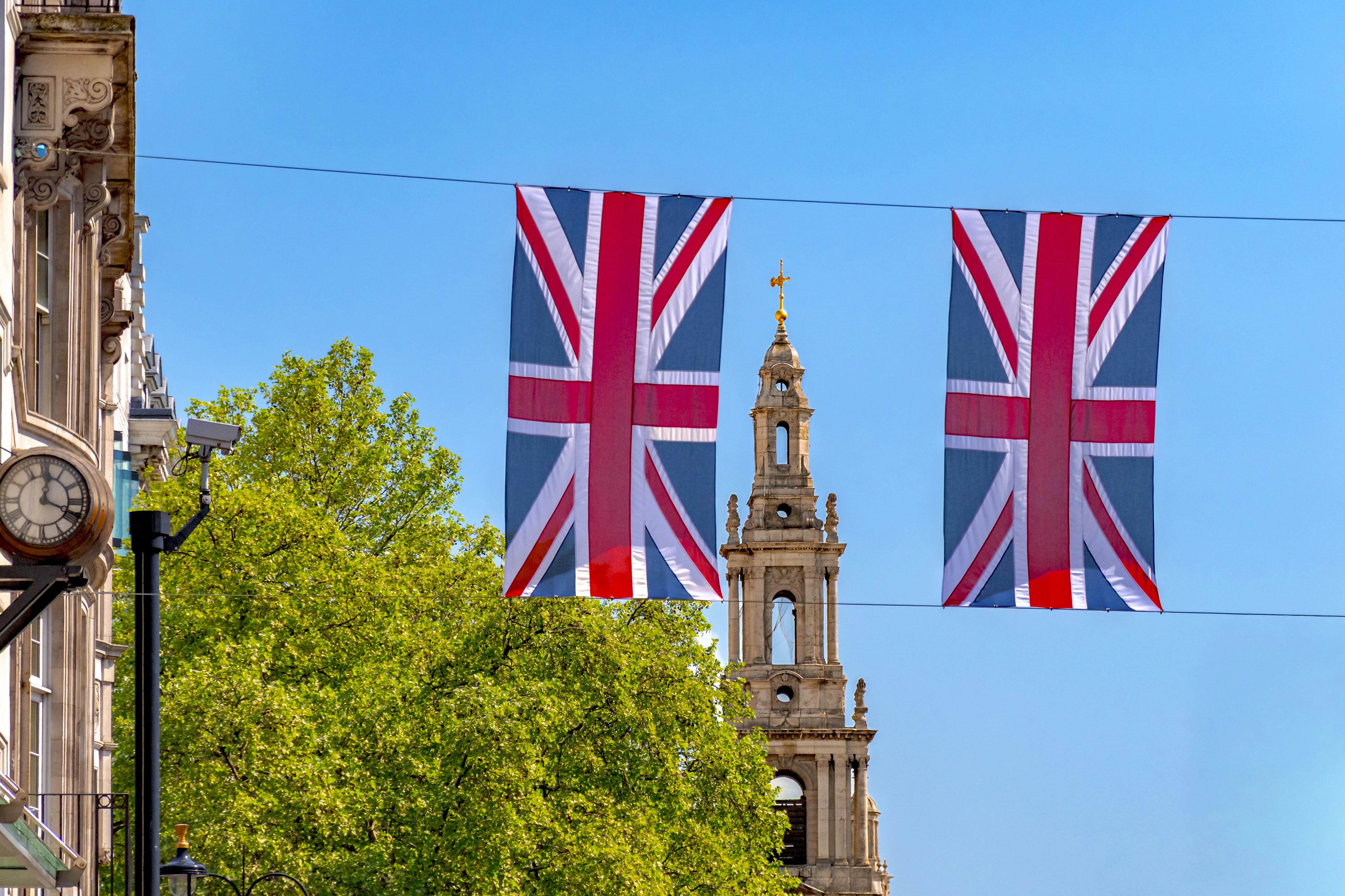 Two union jack flags hang between buildings.