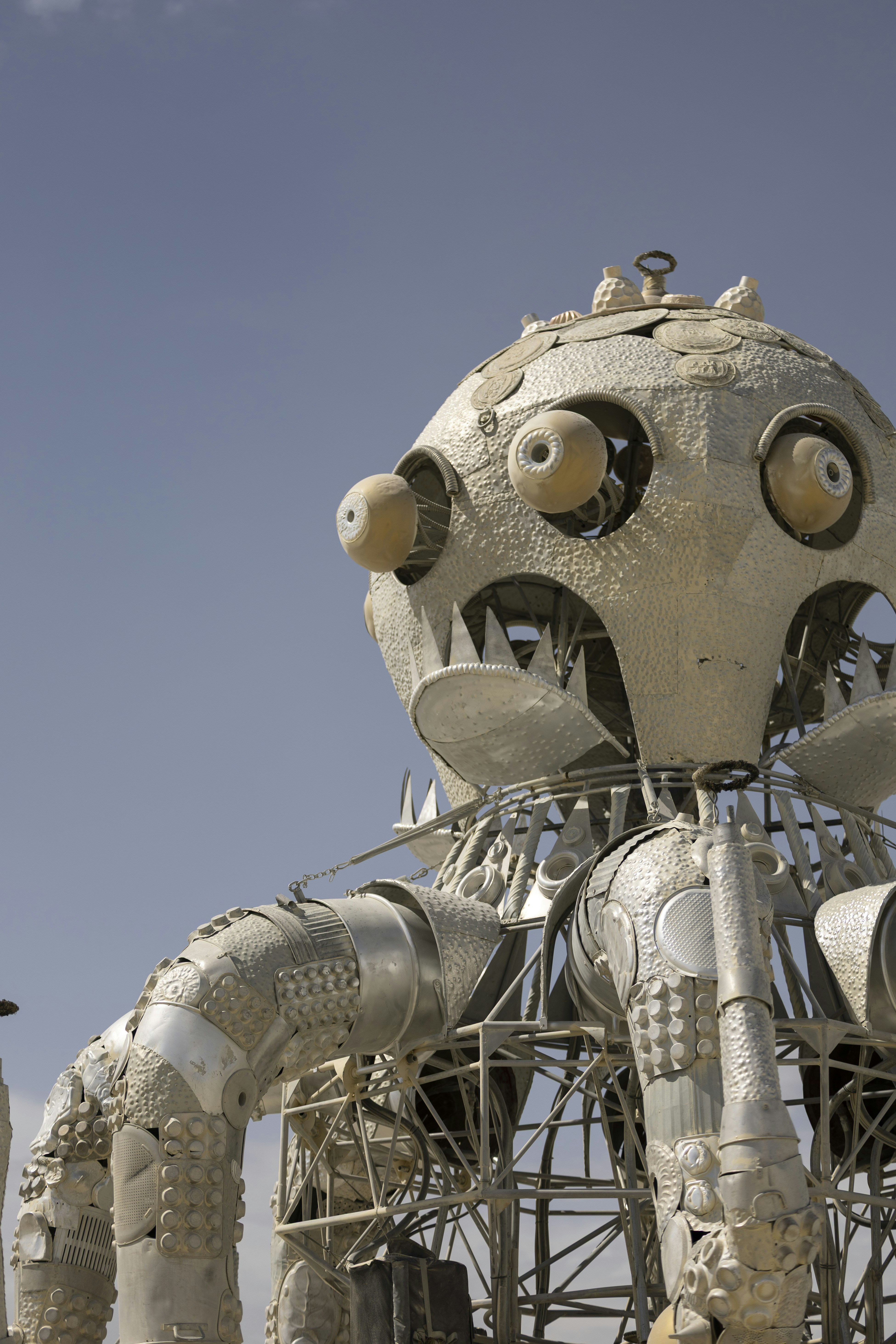 Large metal octopus sculpture against a clear blue sky