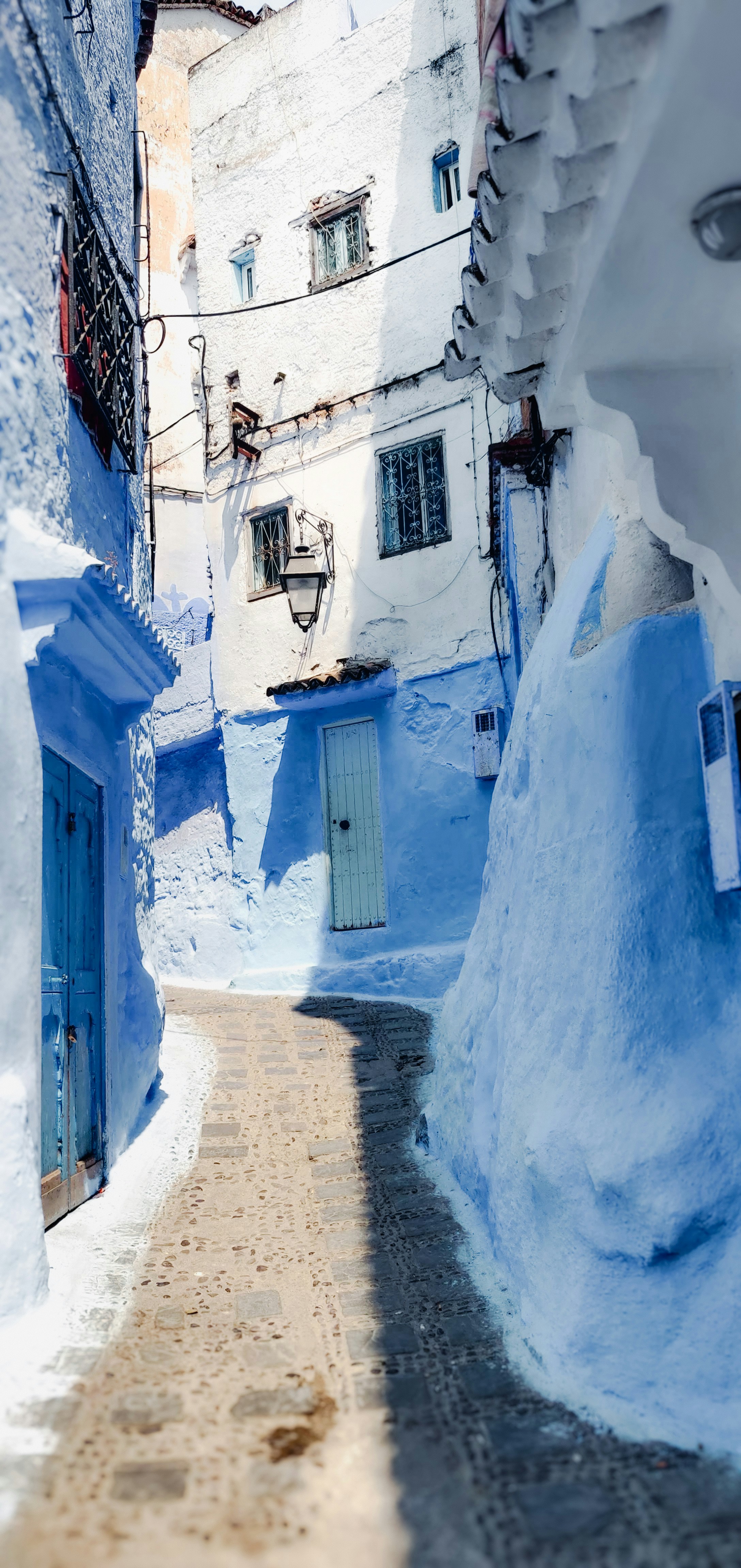 Narrow alleyway with blue and white buildings