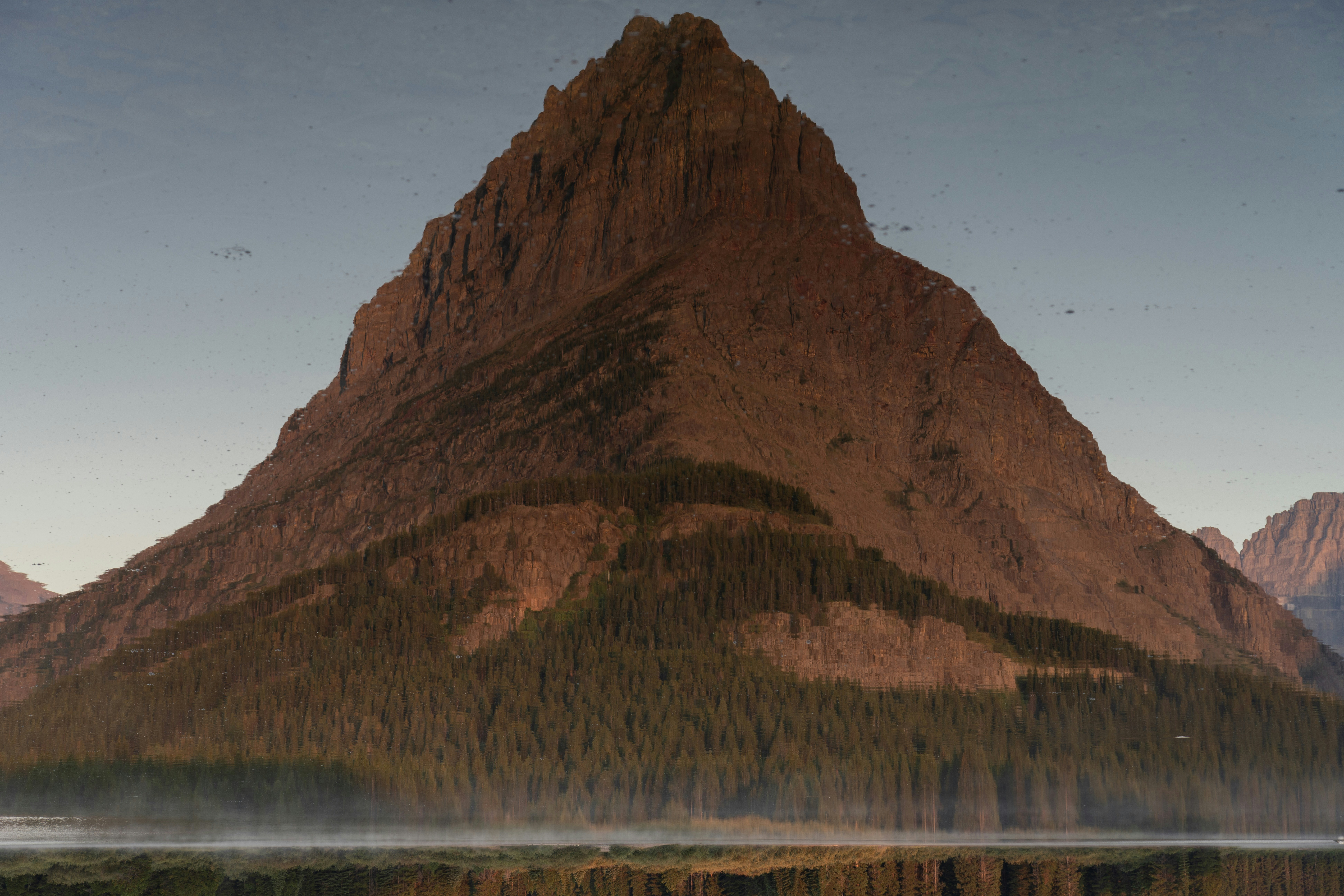 Majestic mountain peak reflected in calm lake at dawn