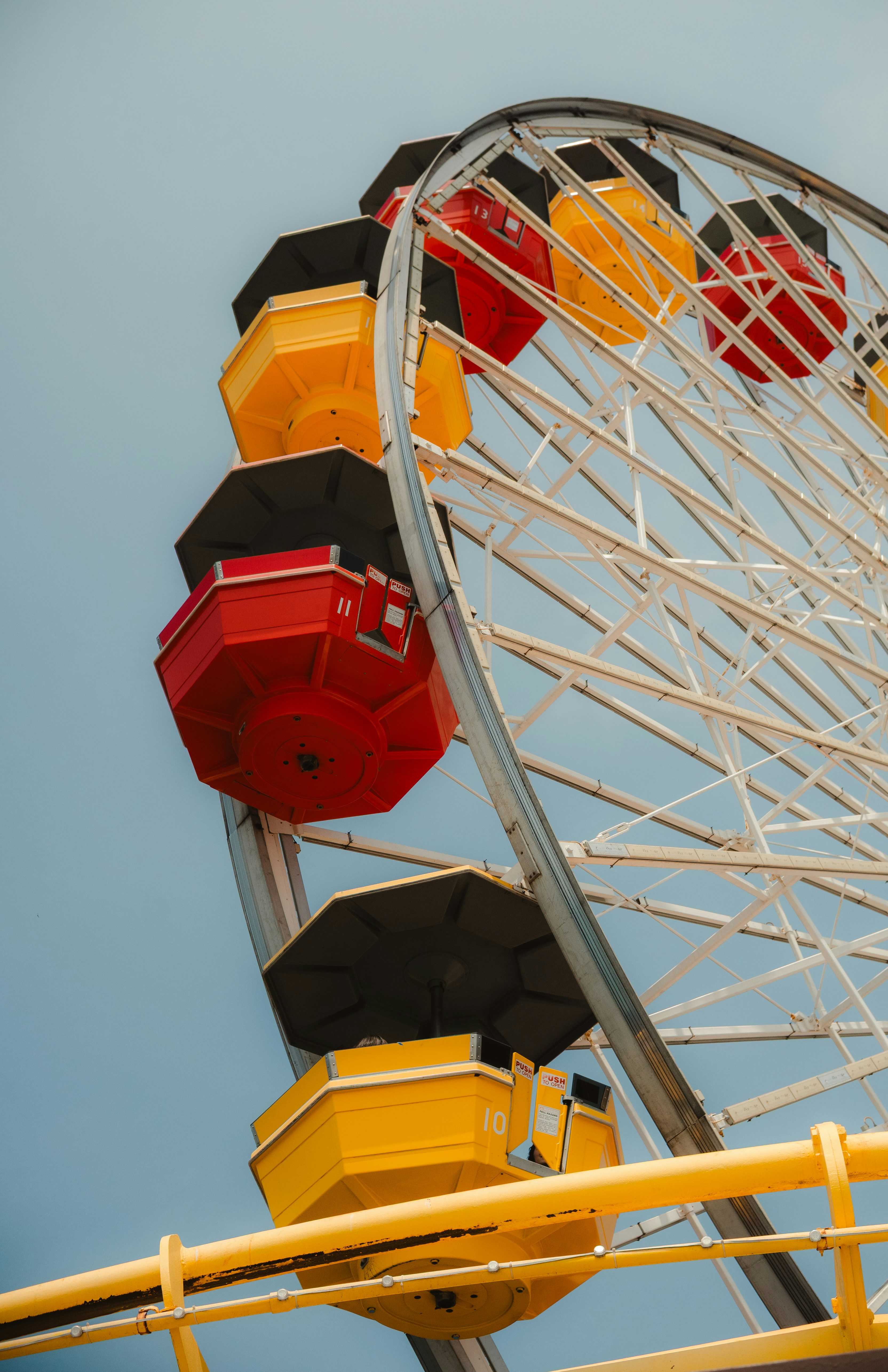 Red and yellow ferris wheel against a cloudy sky