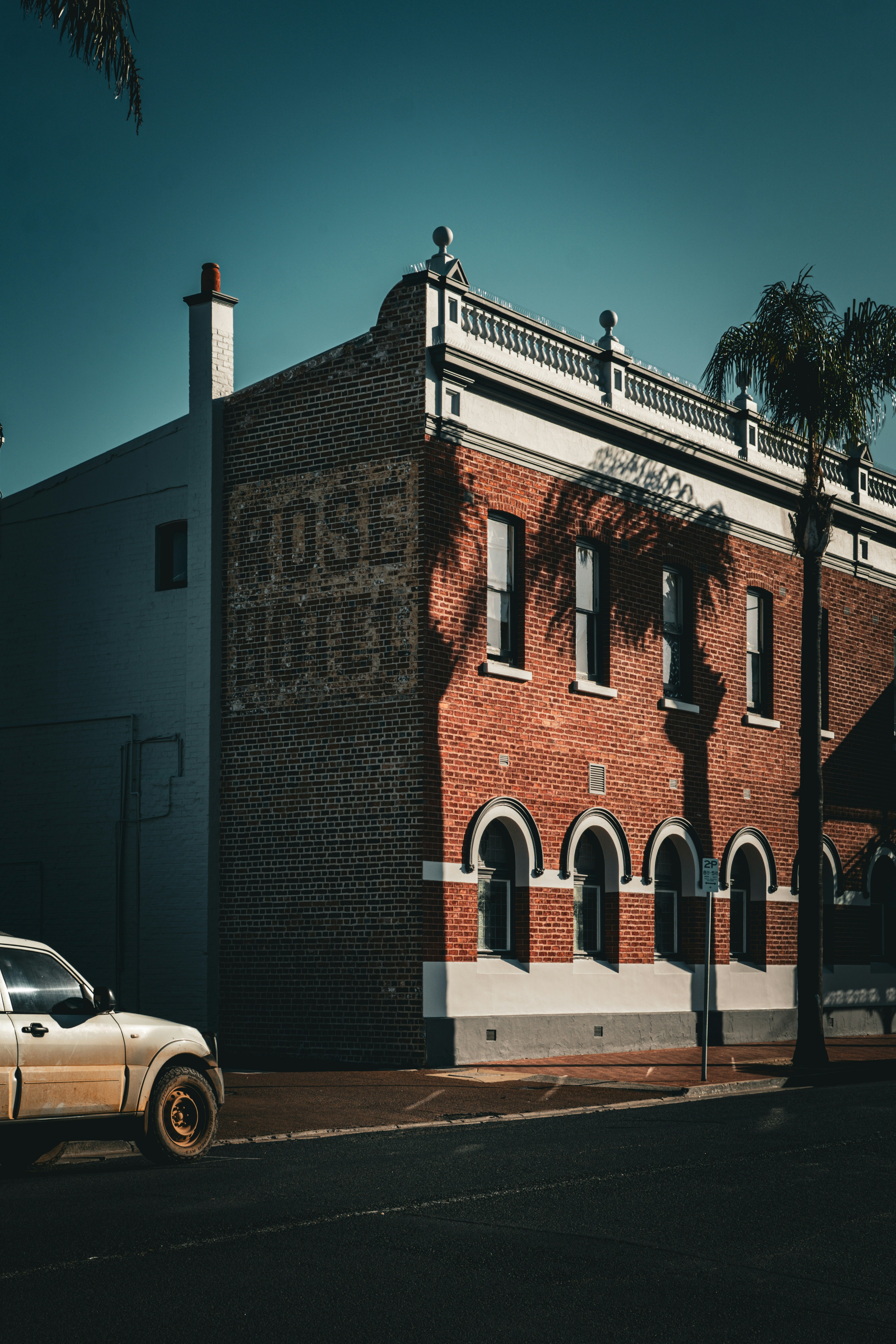 Arches and Palm Shadows: A Brick Street Corner in Quiet Light