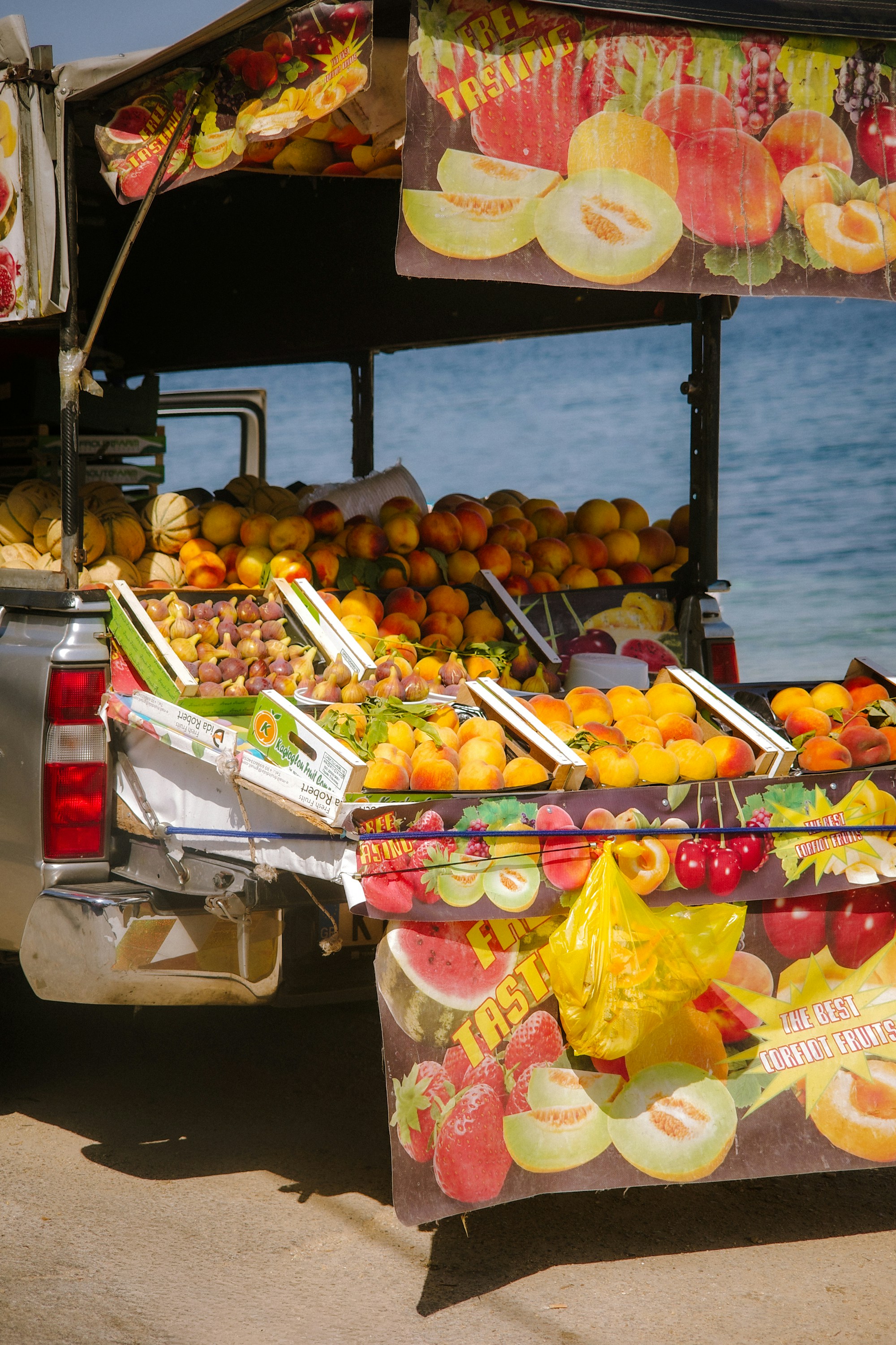 Coastal Fruit Caravan: Sunlit Crates Overflowing with Citrus and Stone Fruits