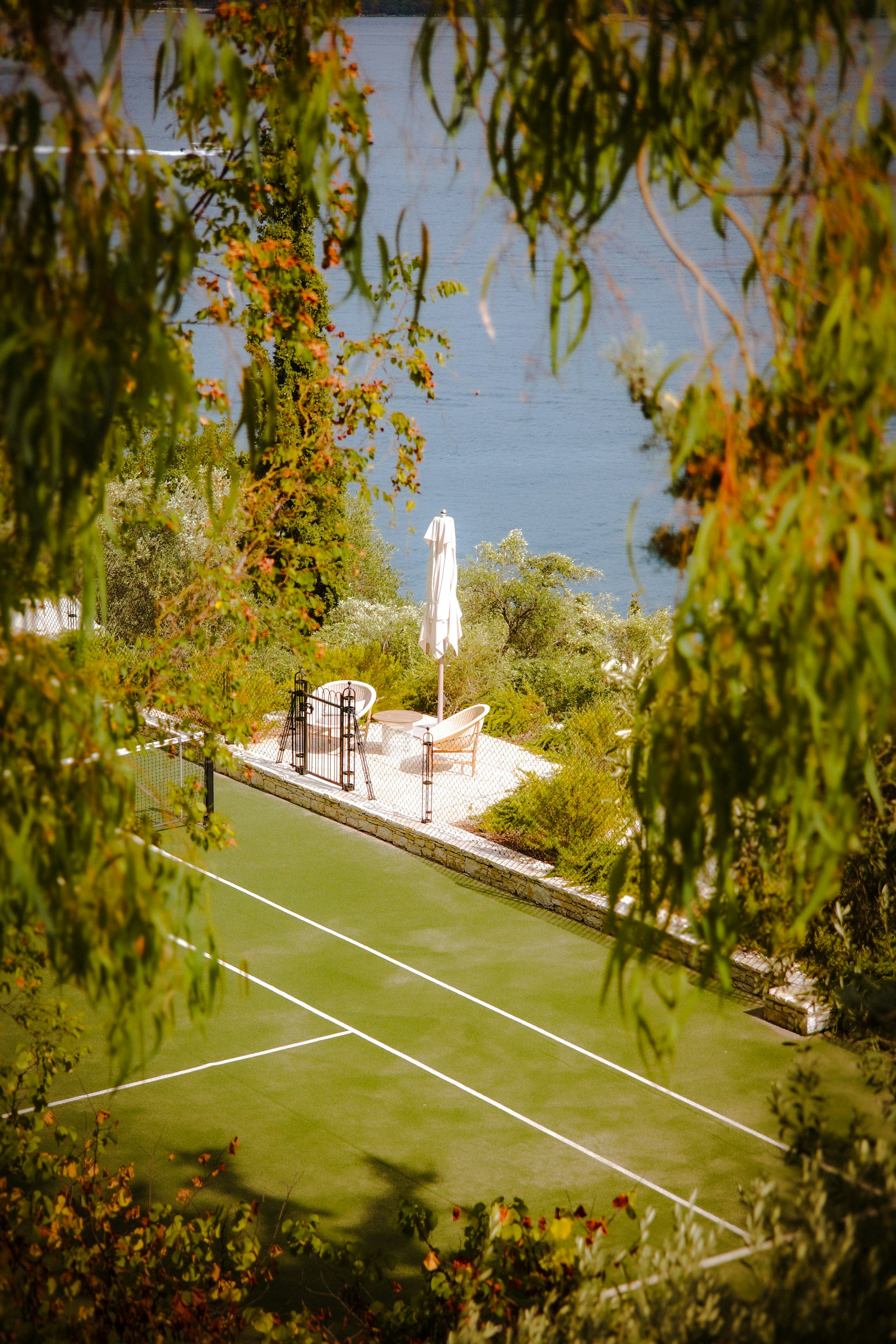 Tennis court with seating area overlooking water photo – Free Greece ...