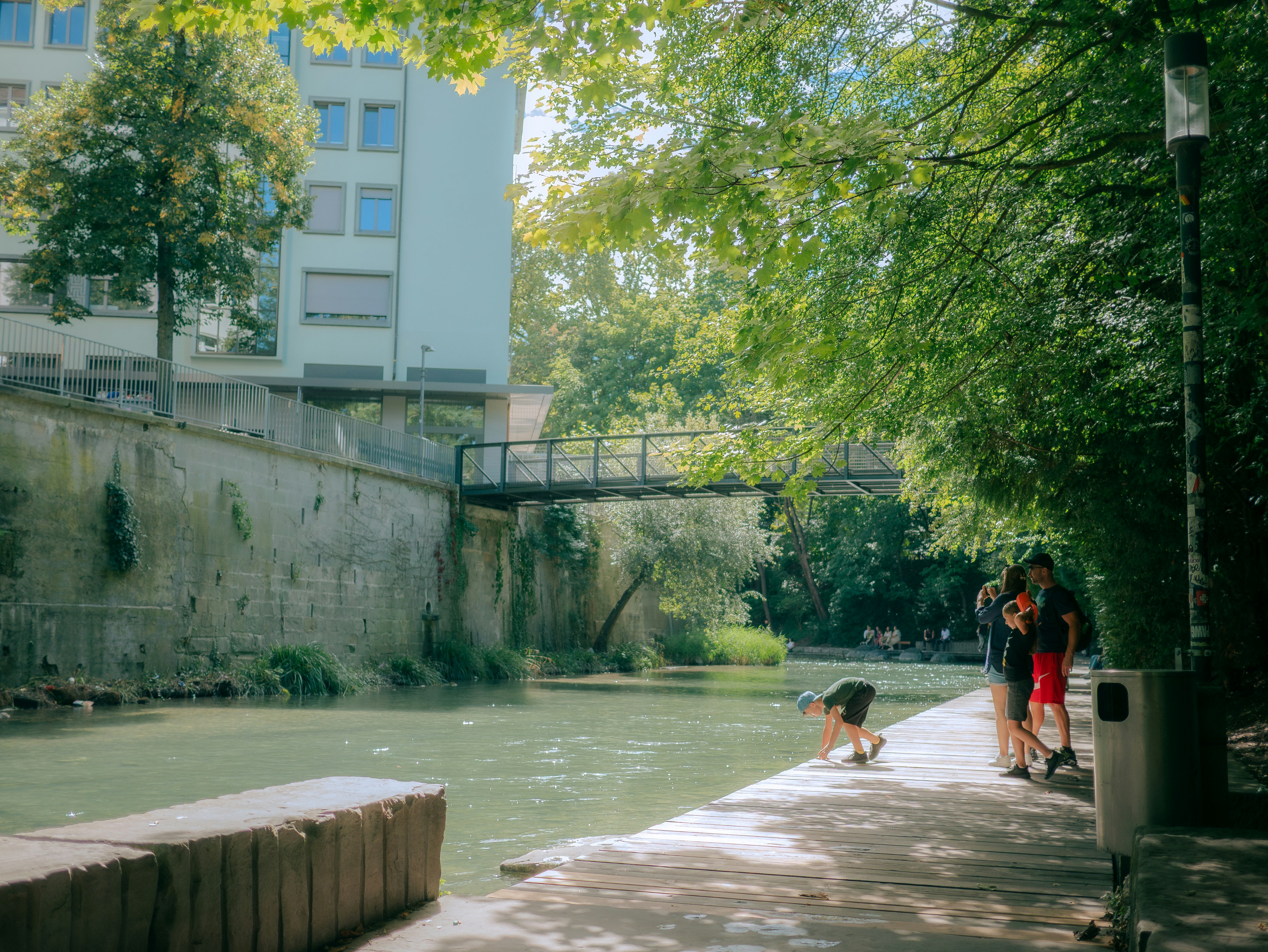 Waterfront Pause: a family by the canal as a child explores the edge