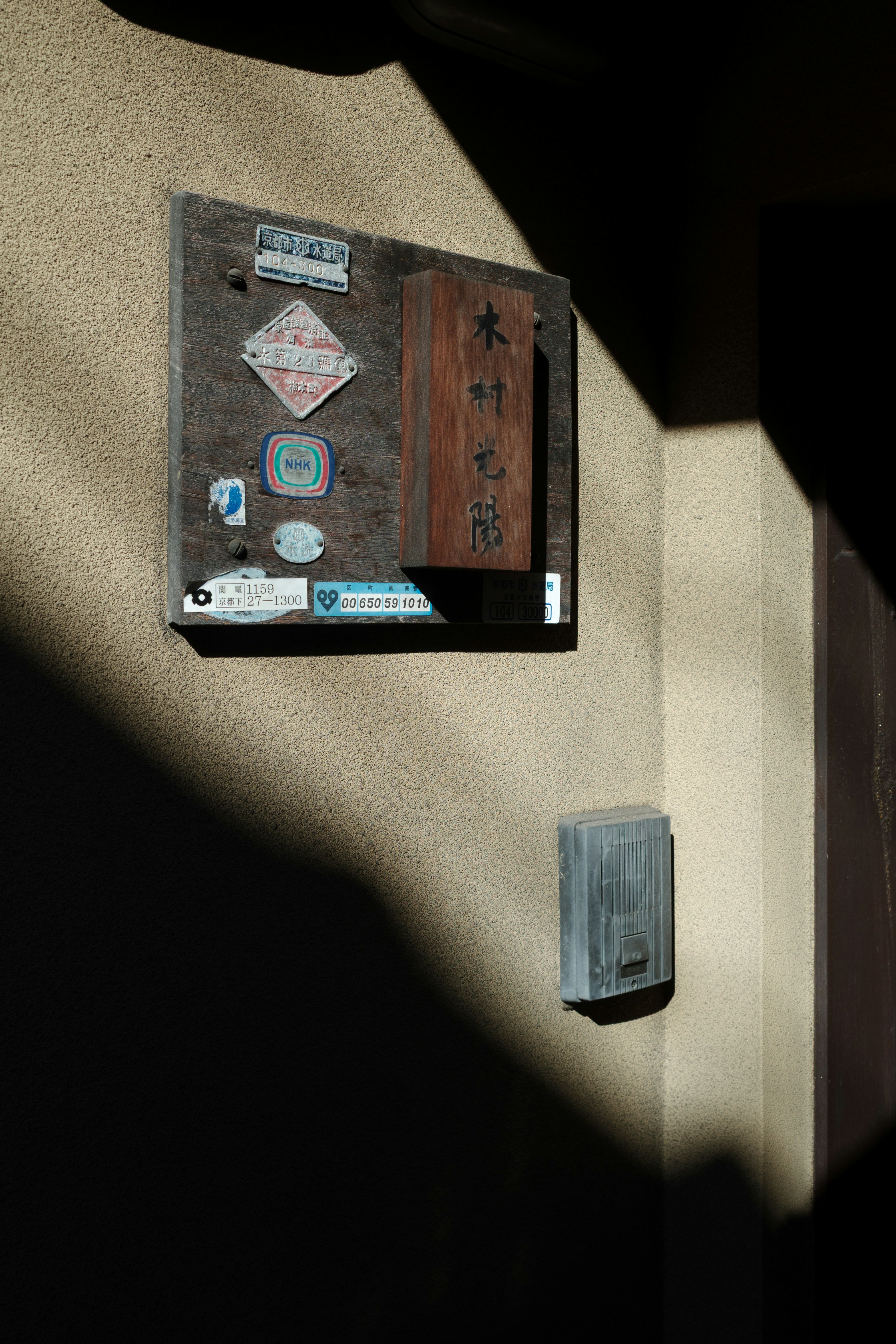 Whispers of Tradition: A Wooden Sign Amidst Urban Shadows