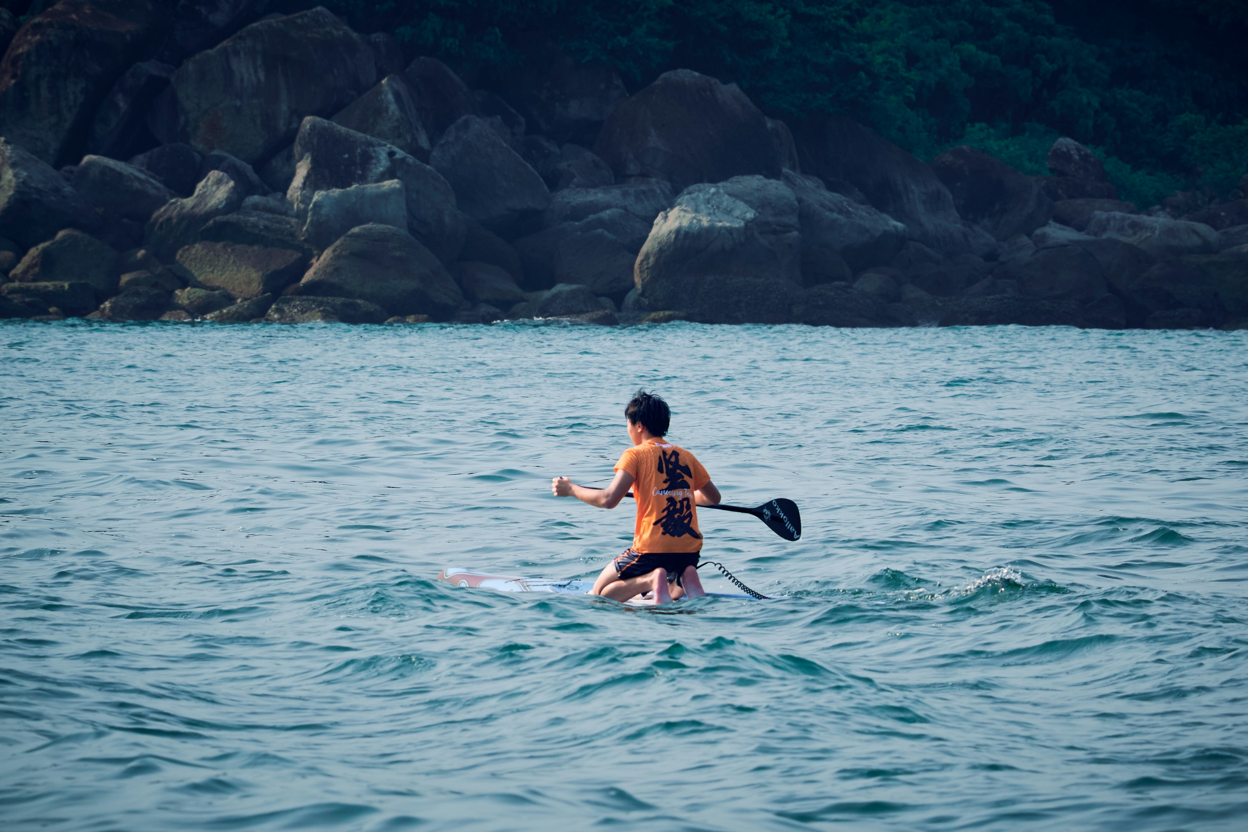 Man kneeling on paddleboard in the ocean
