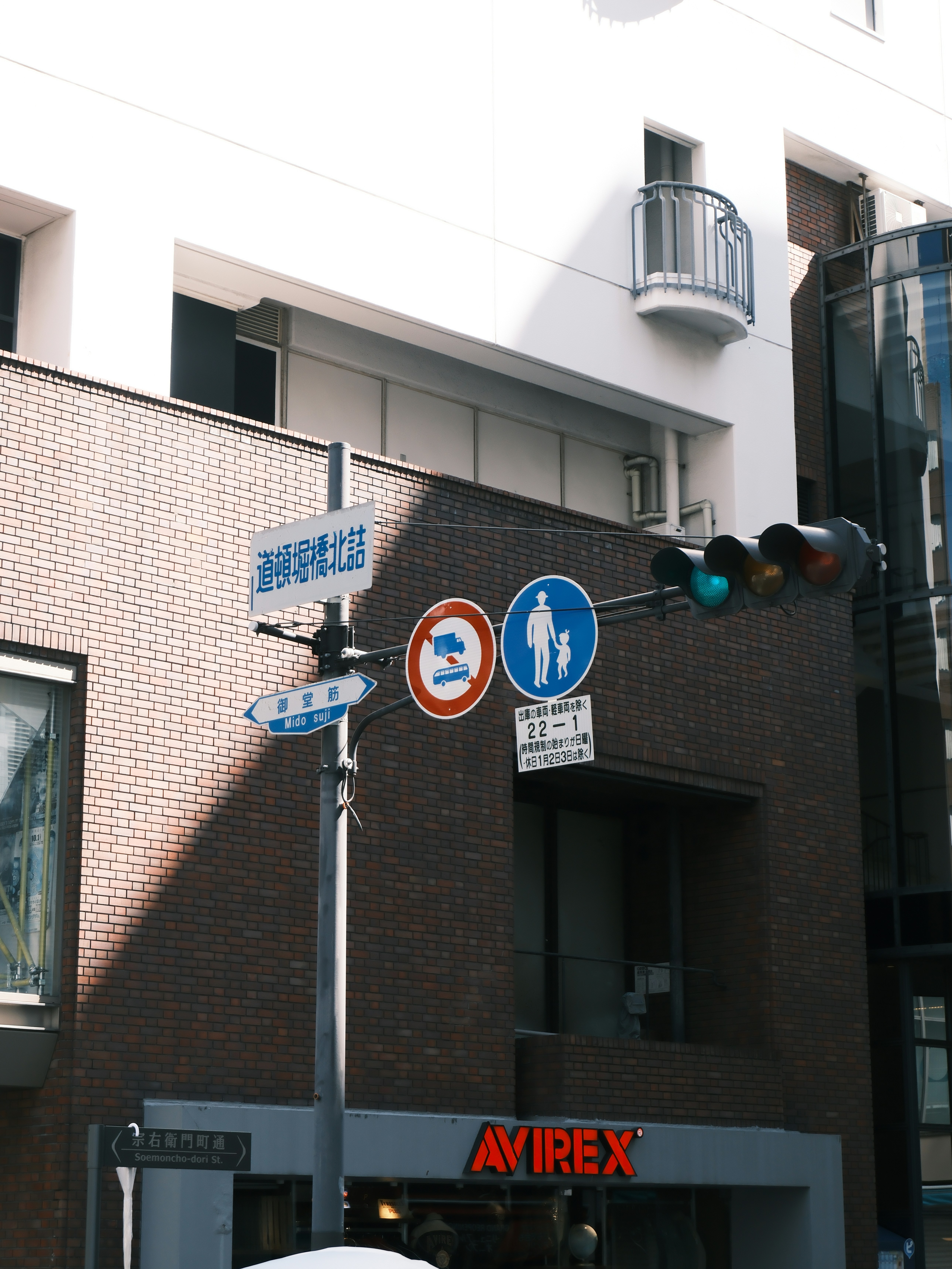 Street signs and traffic light on pole
