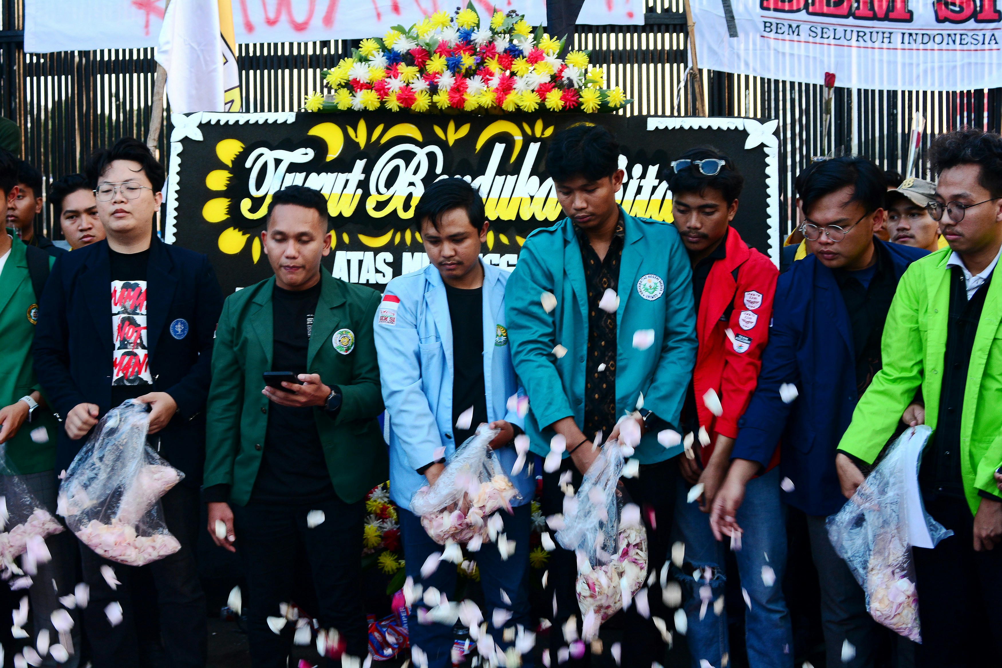 Students from a number of universities held a peaceful demonstration in front of the house of representatives Building in Jakarta, Indonesia, September 4, 2025. | Group of young men scattering flower petals