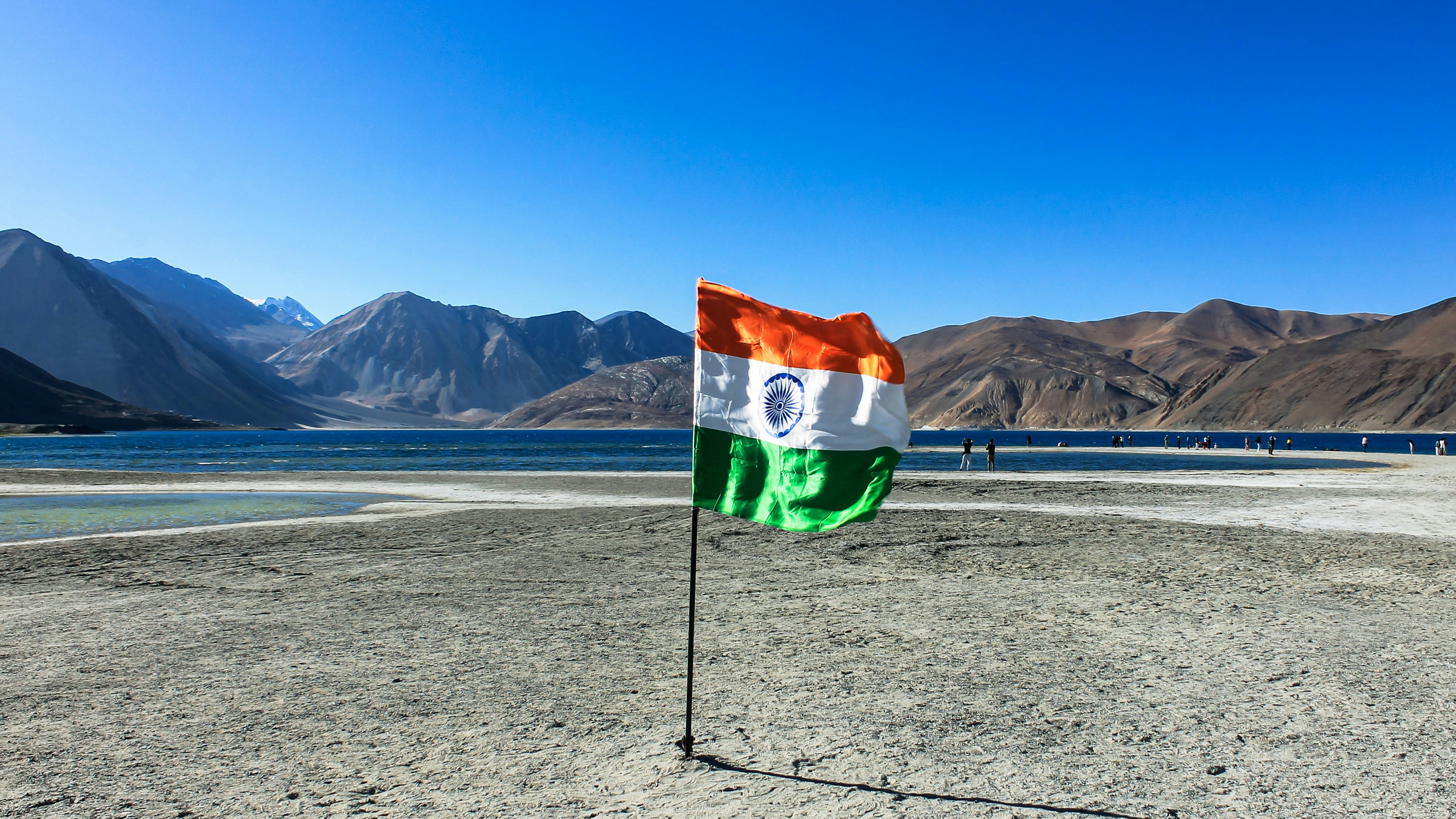 Indian flag flying on a beach with mountains