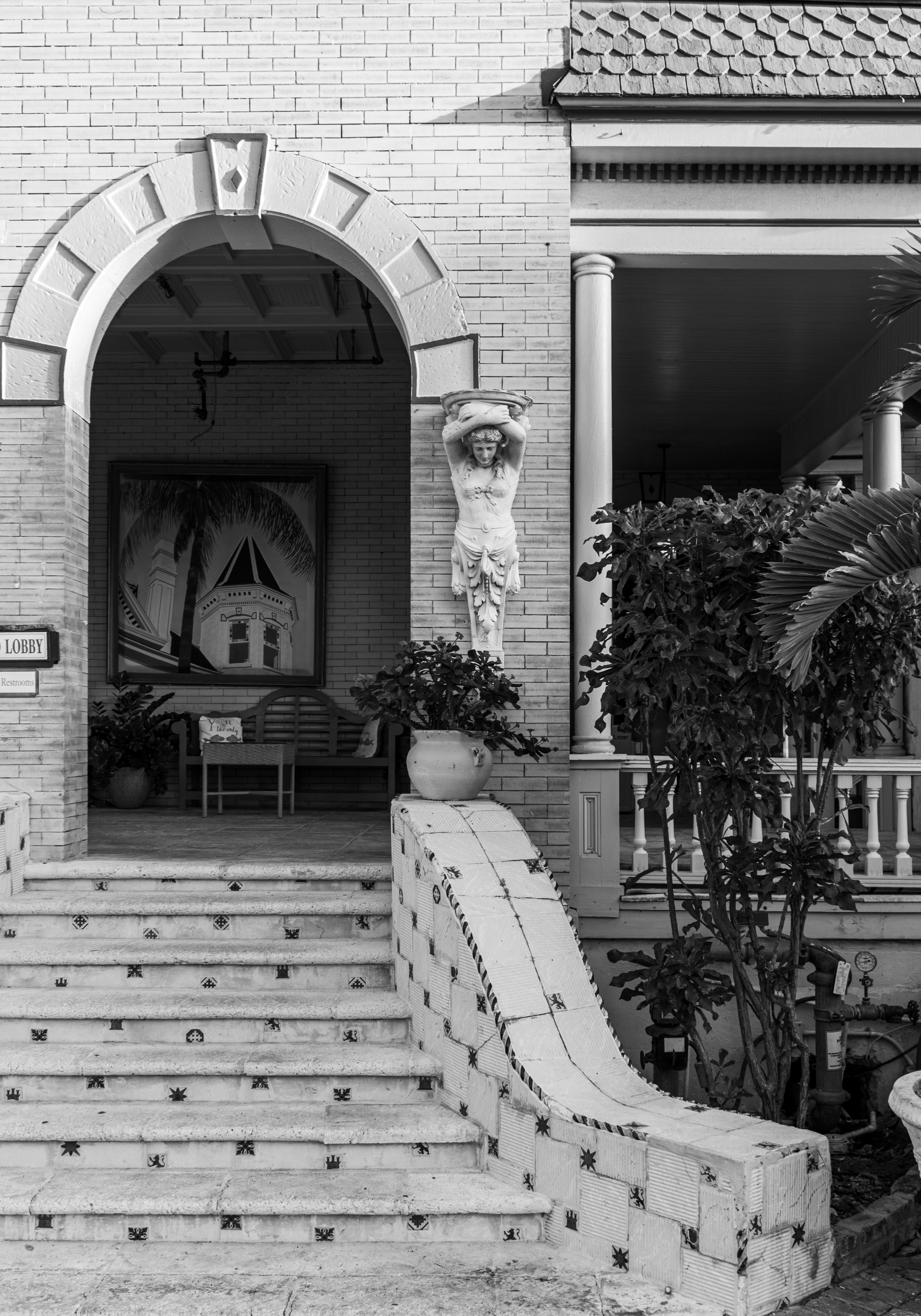 An arched entrance to a hotel lobby | Ornate staircase leading to a historic building entrance.