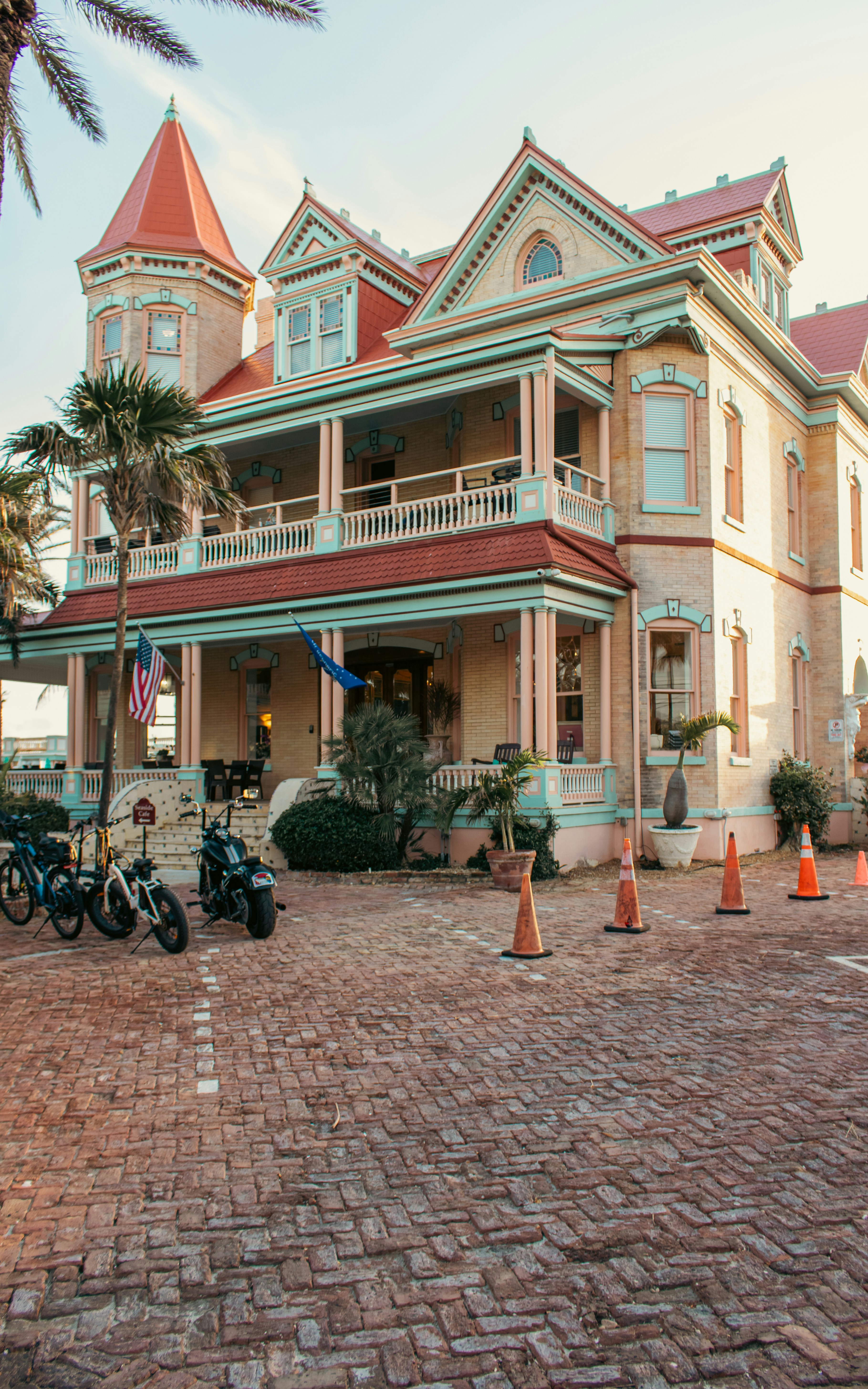 The Southernmost House in Key West, Florida, is a striking Queen Anne Victorian mansion with sweeping ocean views. Built in 1897 by Judge Jeptha Vining Harris, it became the first home in Key West with electricity, thanks to Thomas Edison. Over the years, it has been a speakeasy, a nightclub, and a private residence before becoming today’s boutique bed and breakfast. Famous visitors have included Ernest Hemingway, Louis Armstrong, and five U.S. Presidents, adding to the mansion’s rich legacy as a Key West landmark. | Victorian mansion with a red roof and balconies