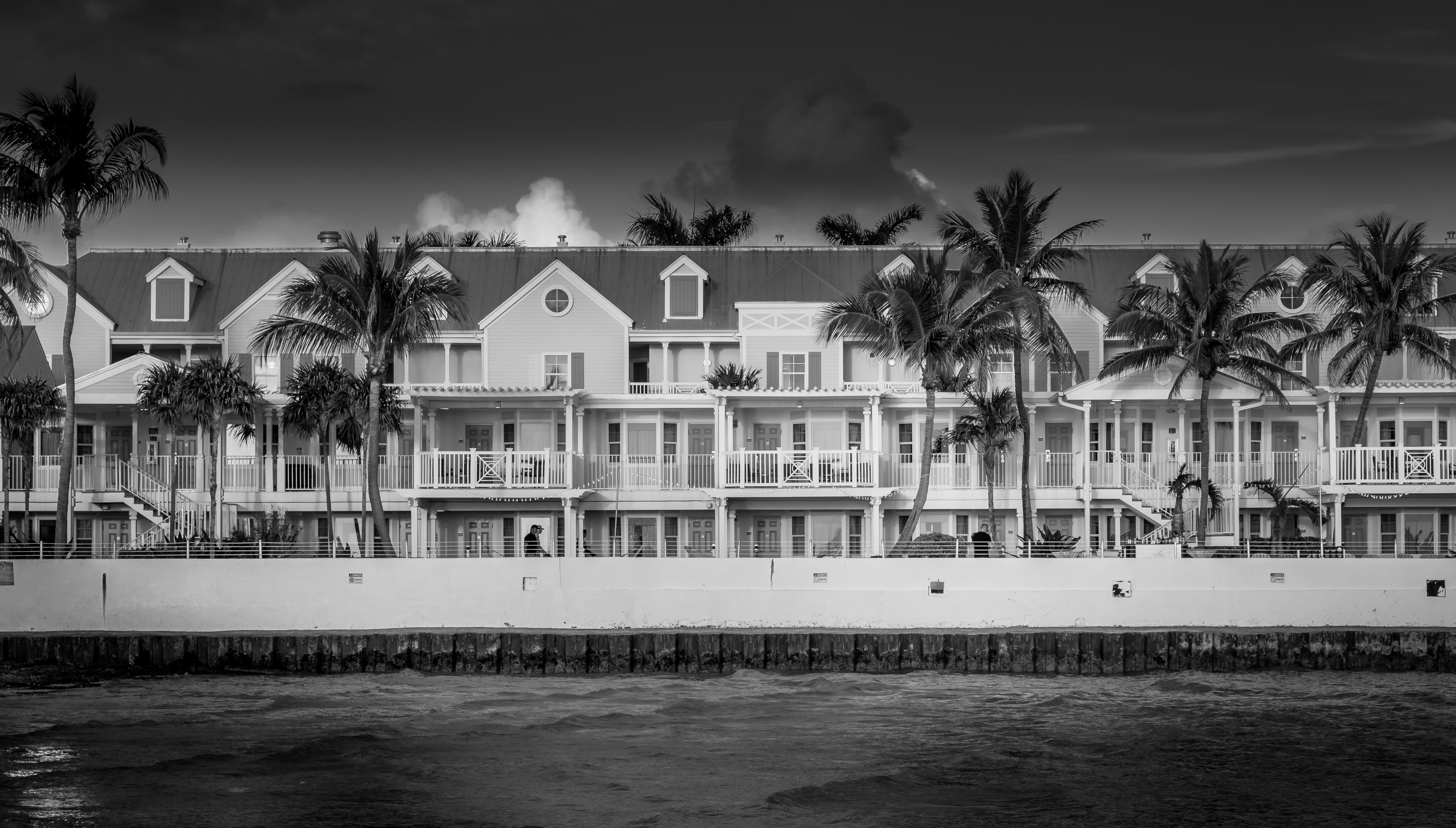 The award winning Southernmost Beach Resort Key West is a simple, yet sophisticated resort in historic Old Town Key West, where Duval Street meets the Atlantic Ocean. | Row of tropical buildings with palm trees and balconies.