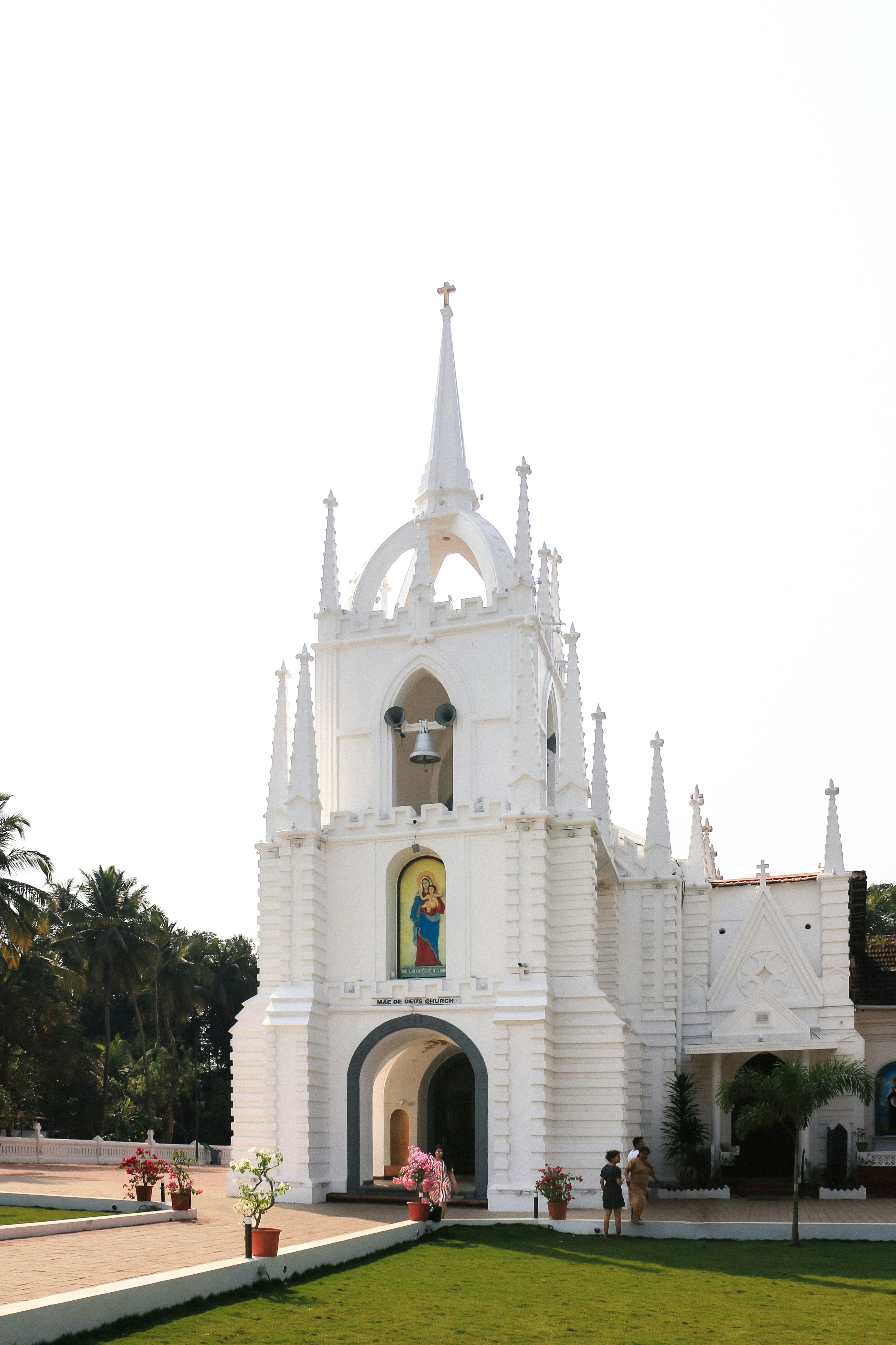 A white church with a tall steeple and bell tower.