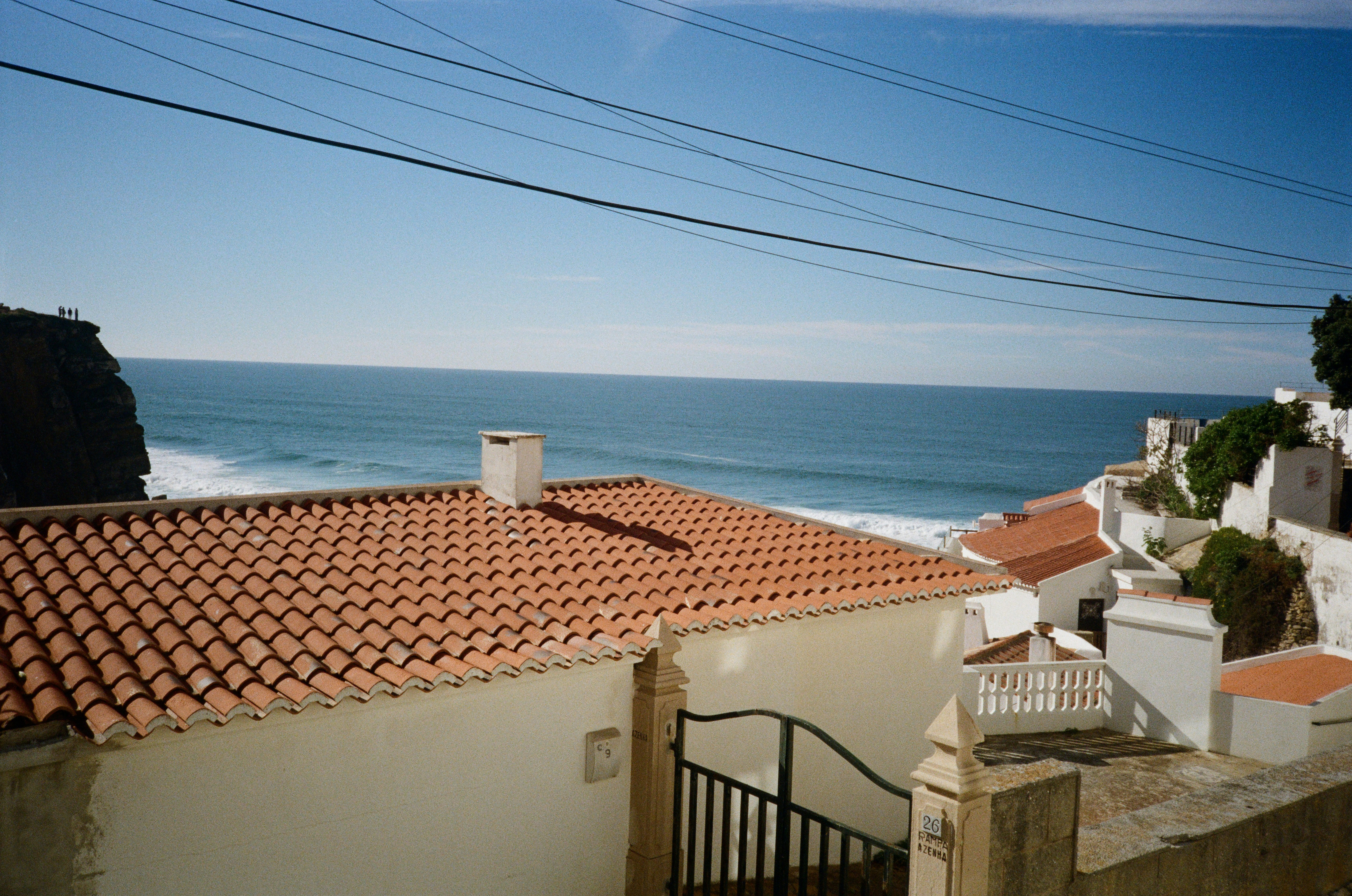 White buildings and tiled roofs overlook ocean waves. photo – Free Film ...