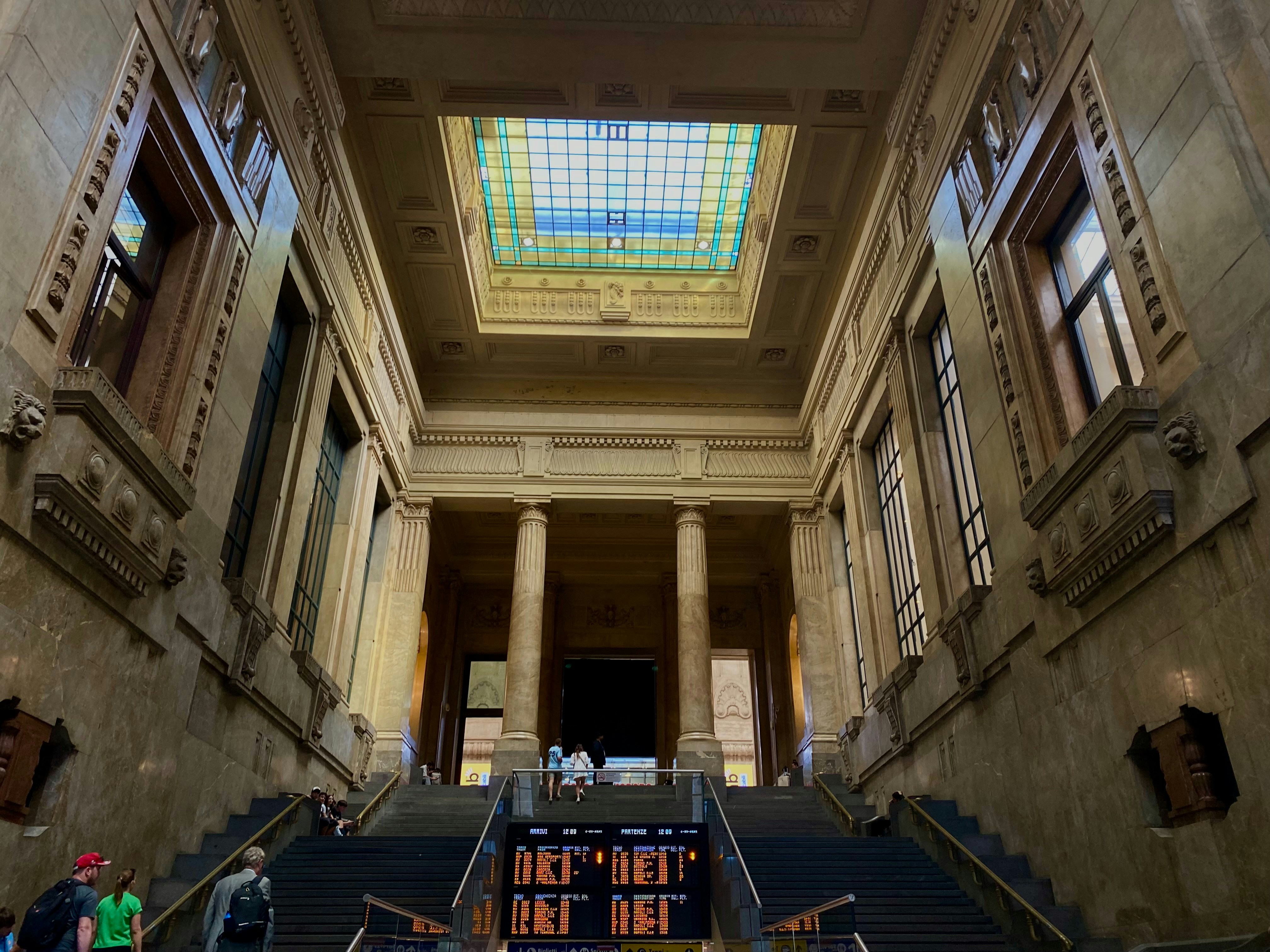 Grand staircase inside a historic building with skylight.