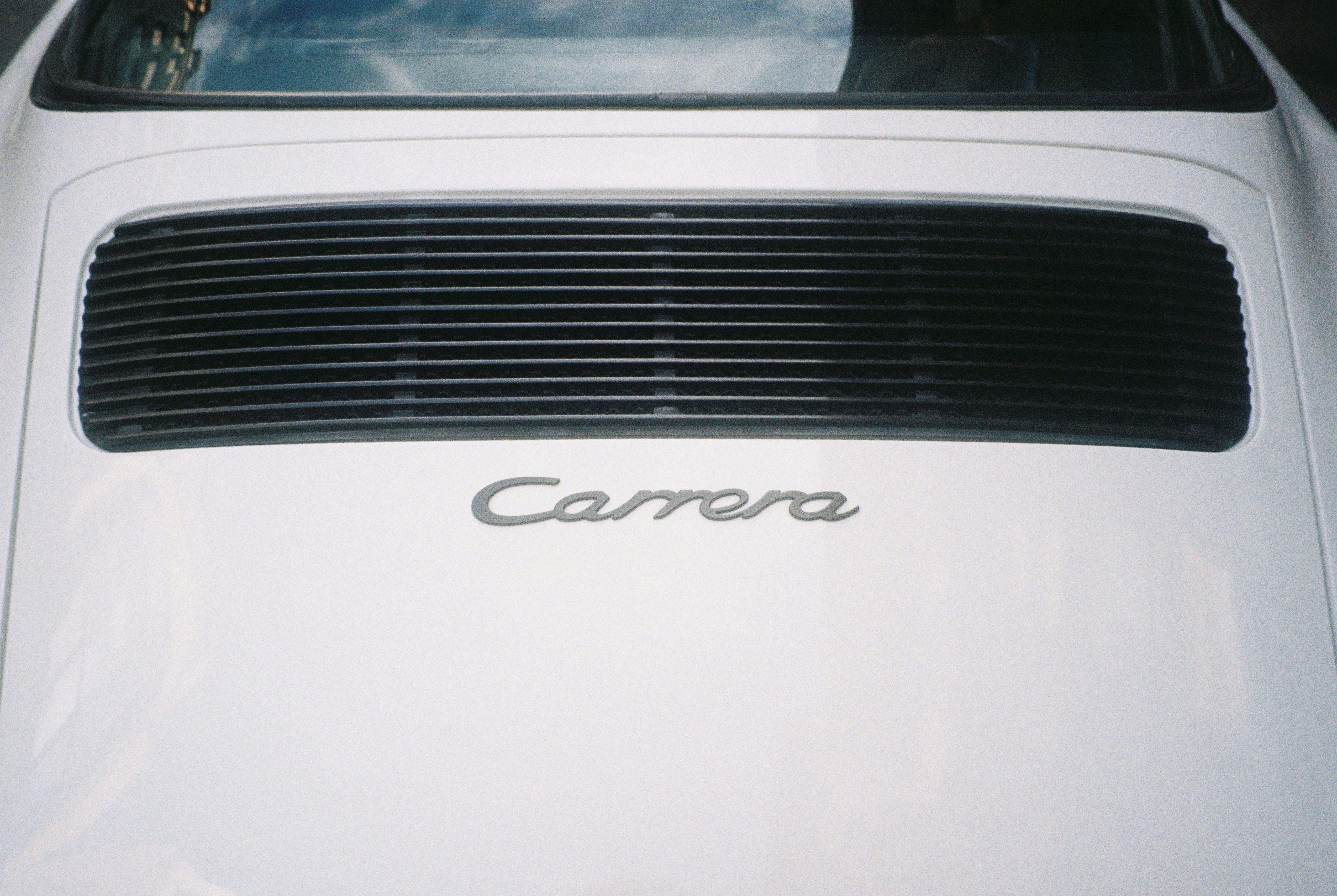 Shot on Kodak Gold 200 | White car rear with carrera emblem