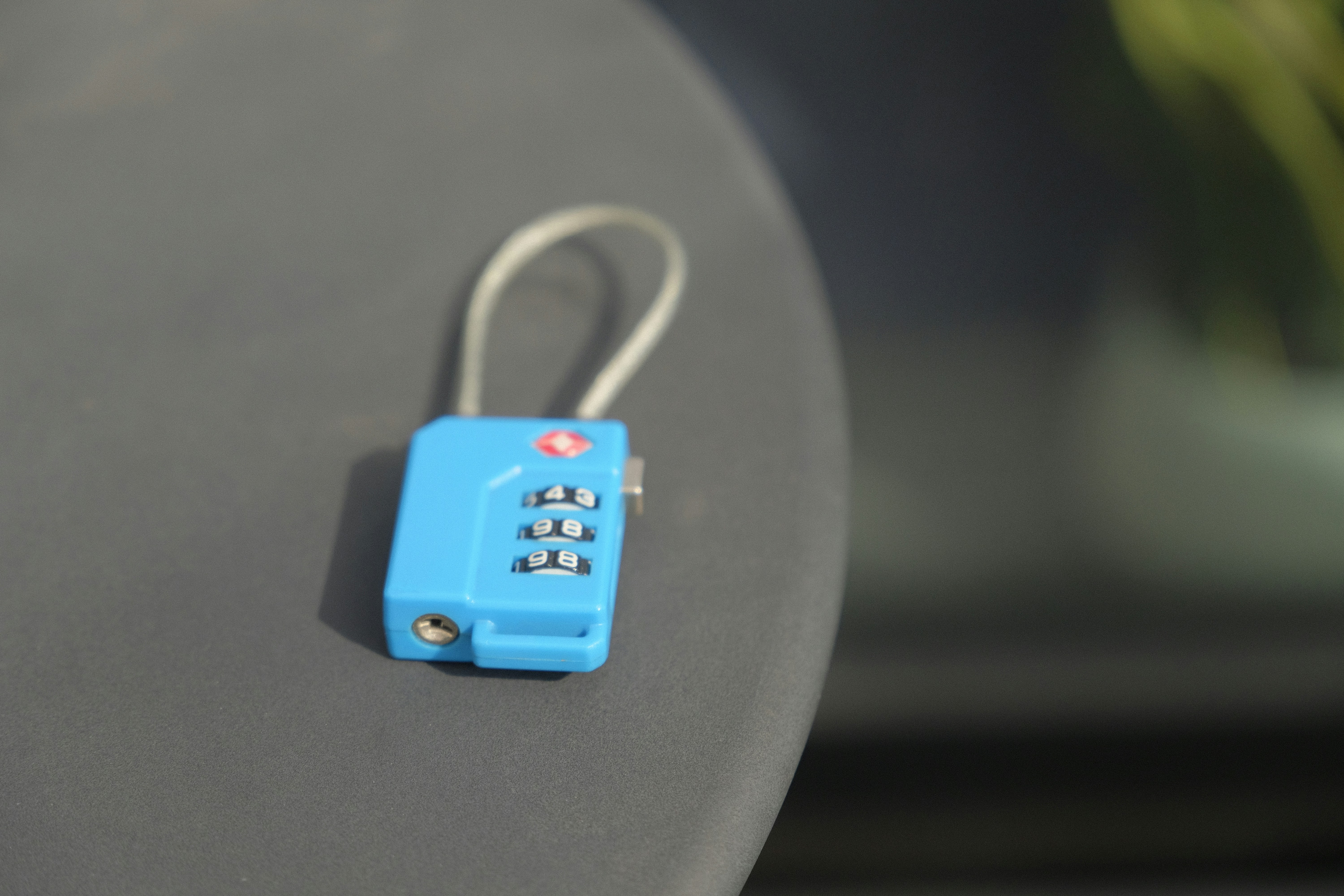 A small blue combination lock rests on a surface. photo – Free Padlock ...