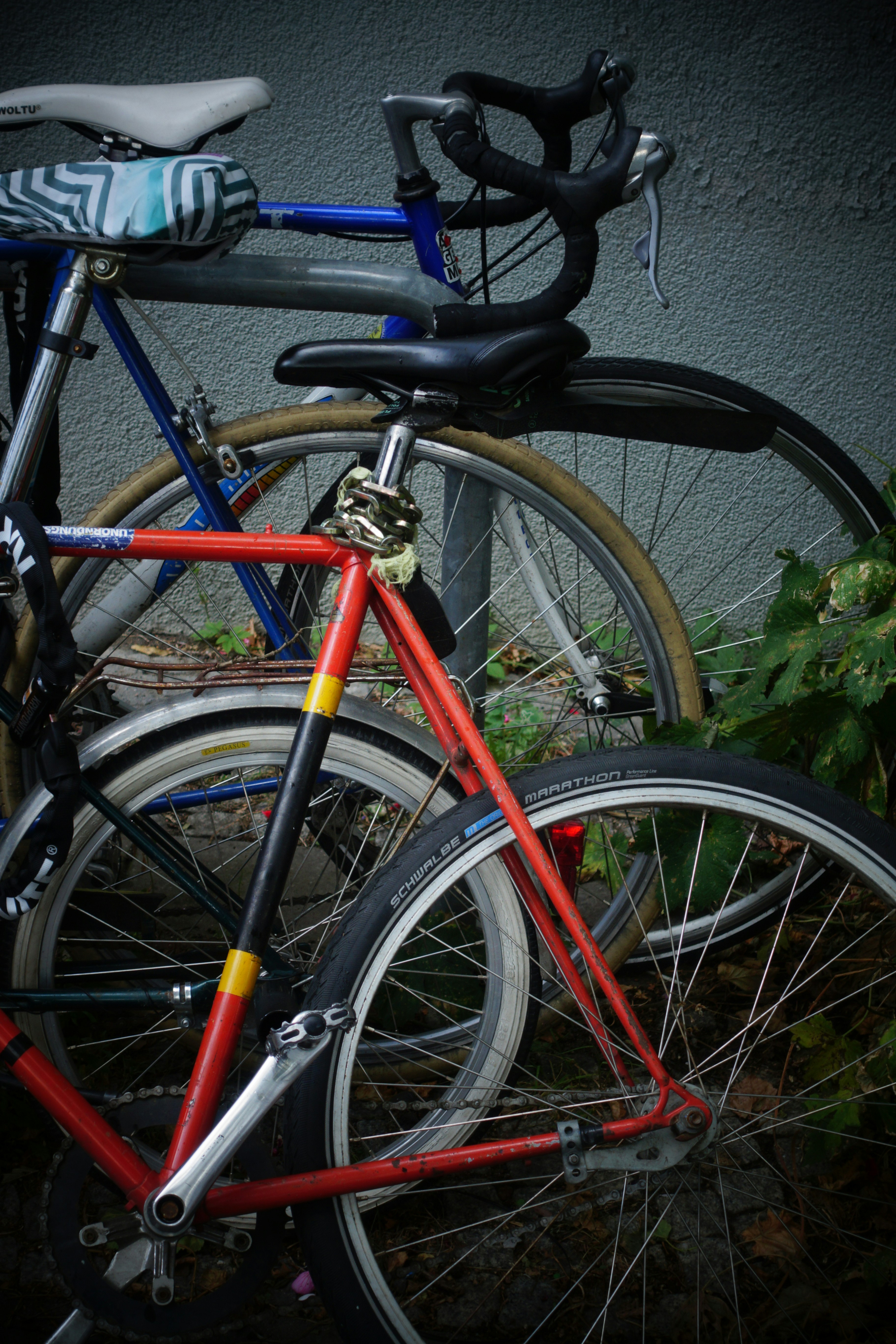 Several bicycles parked next to a wall.