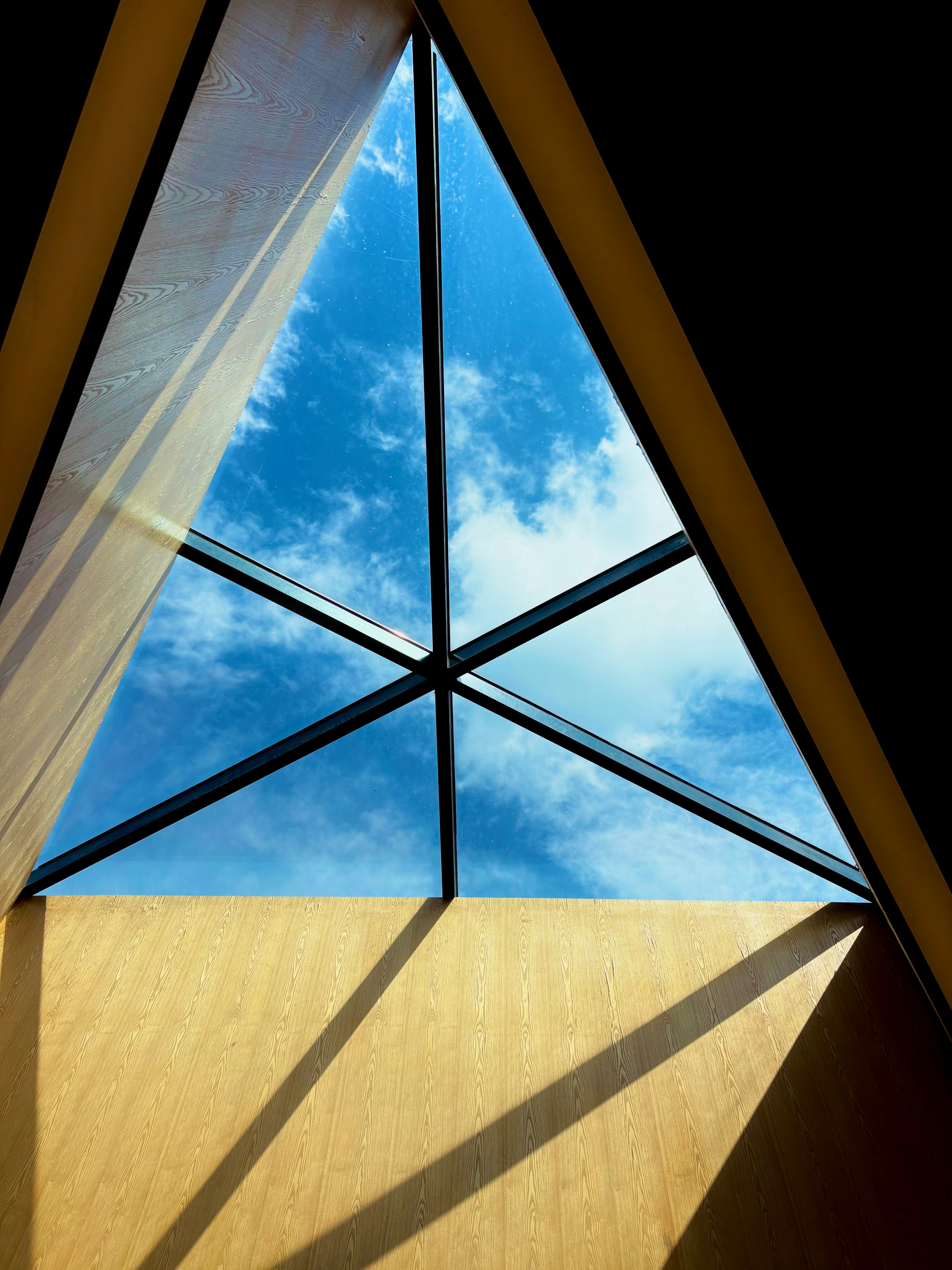 Triangular skylight revealing a bright blue sky.