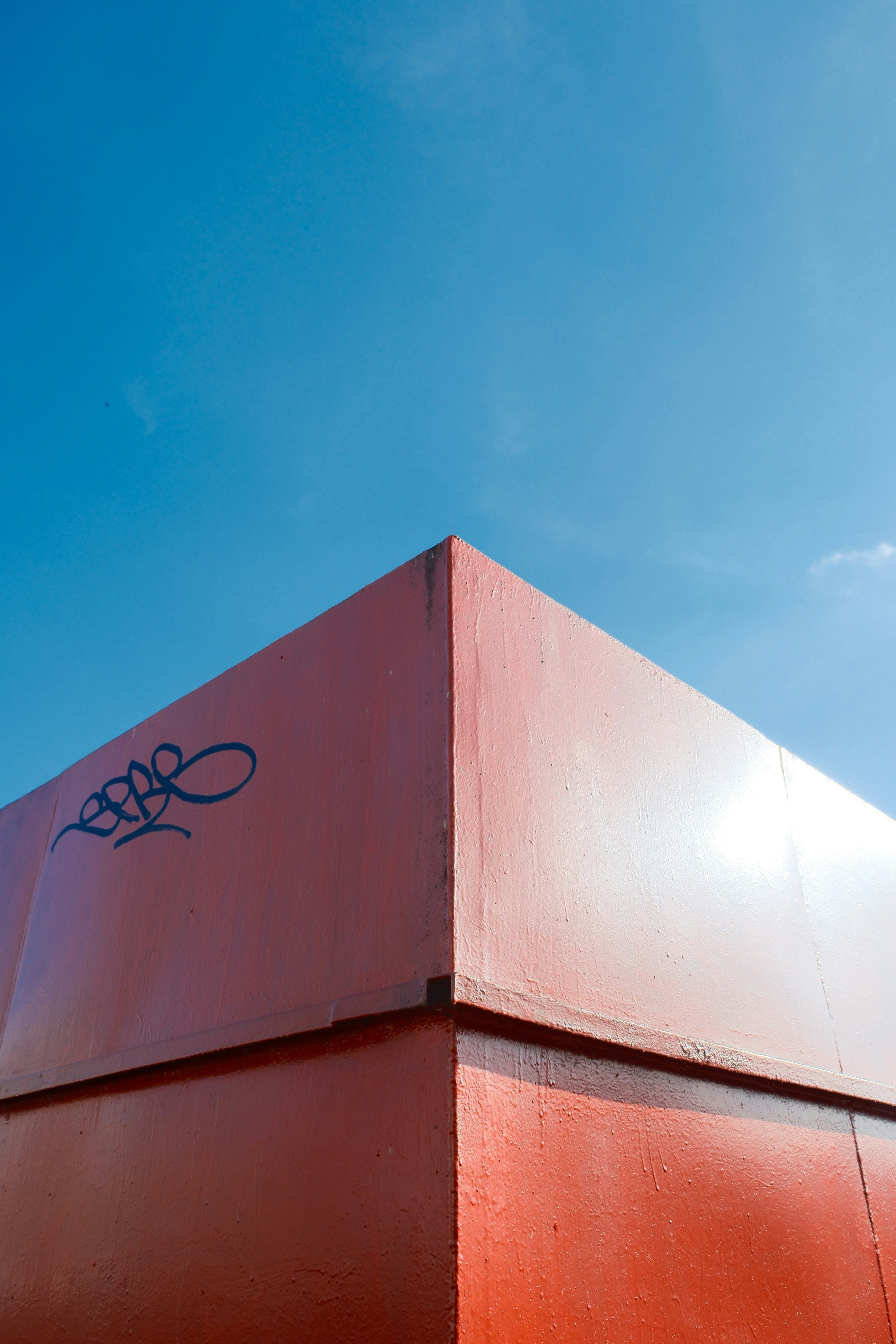 Red corner structure against a clear blue sky