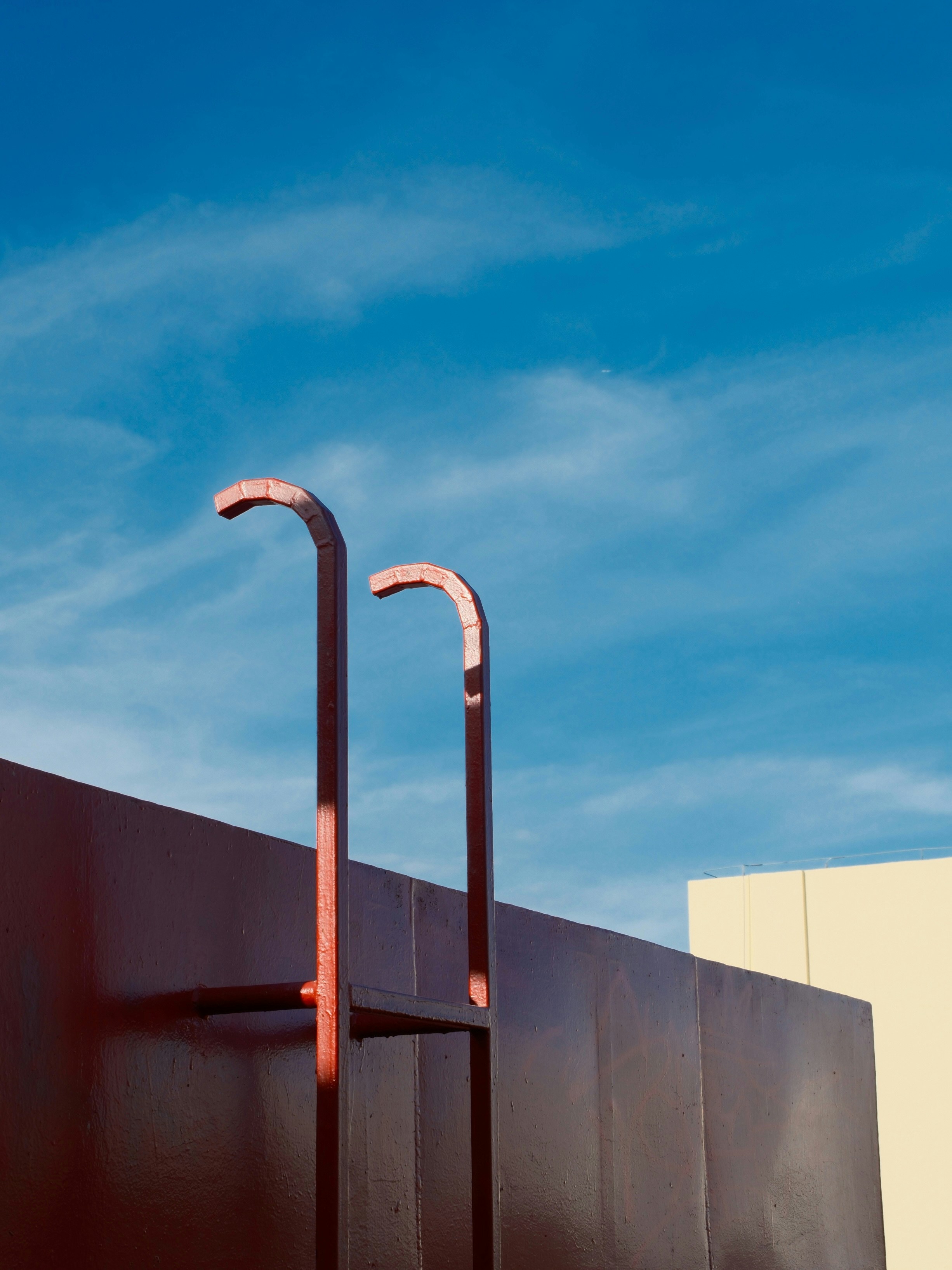 Blue&Red | Red ladder against a bright blue sky.