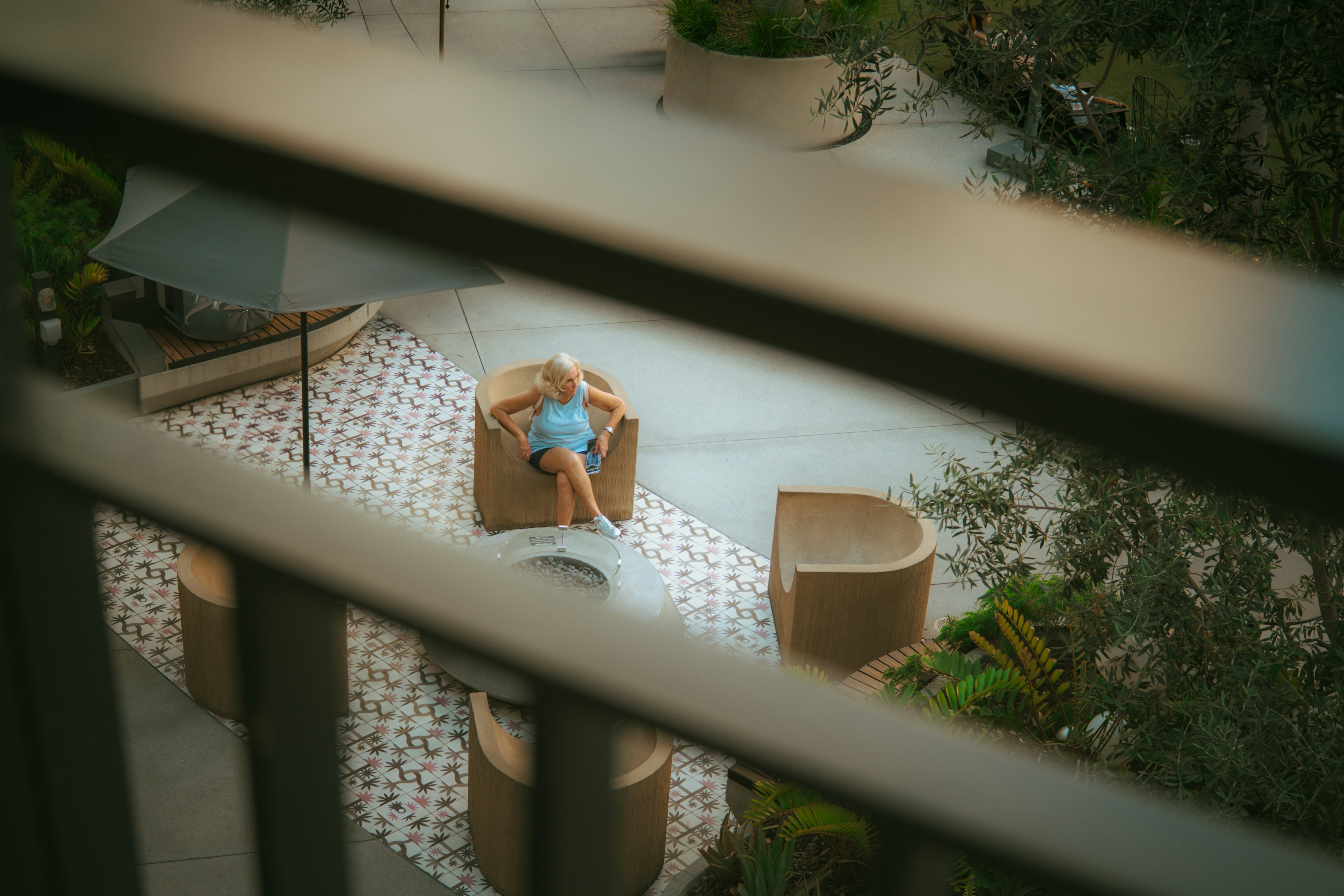 Woman relaxes in an outdoor seating area.