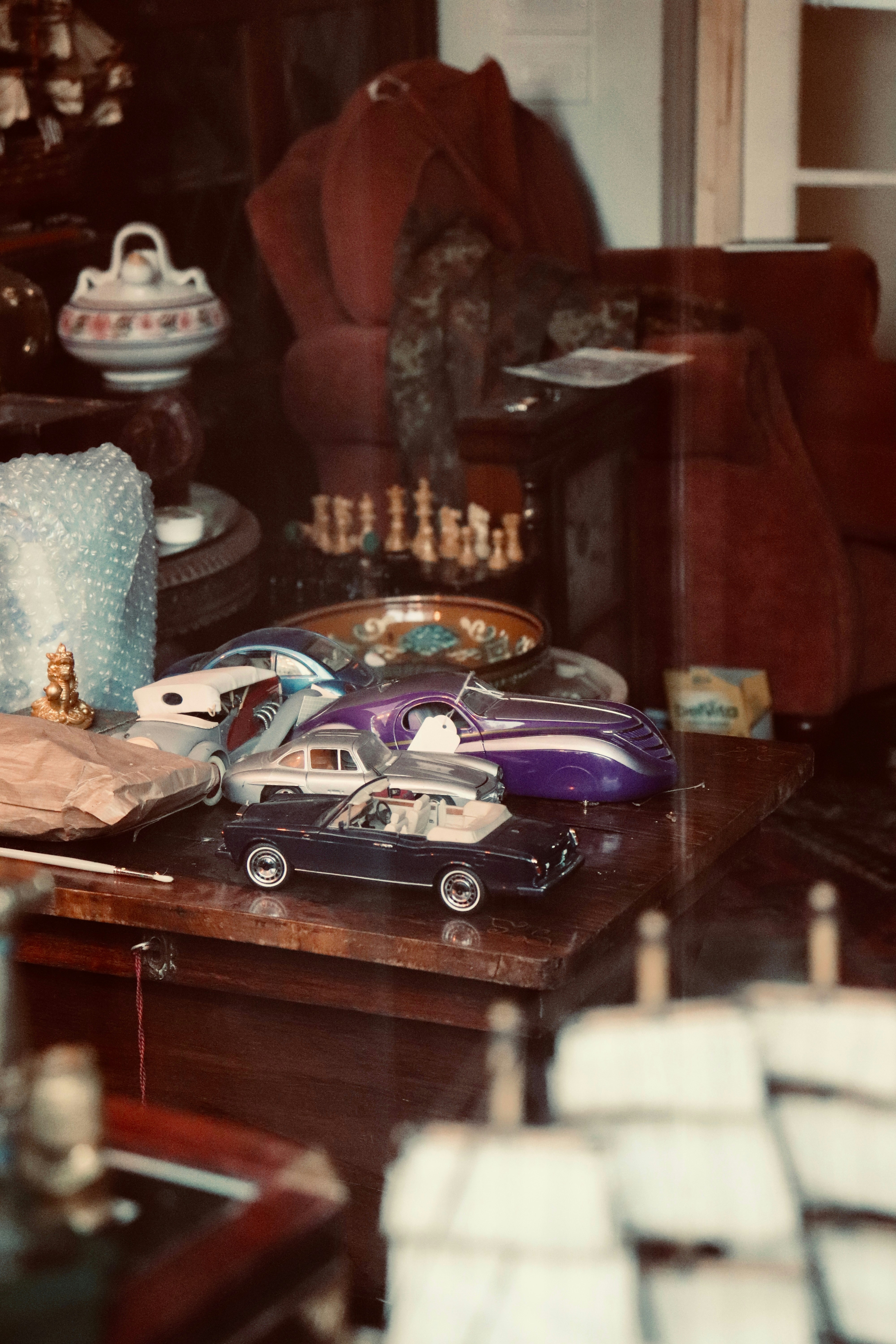 Whispers of Walnut: A Row of Model Cars in a Vintage Parlor