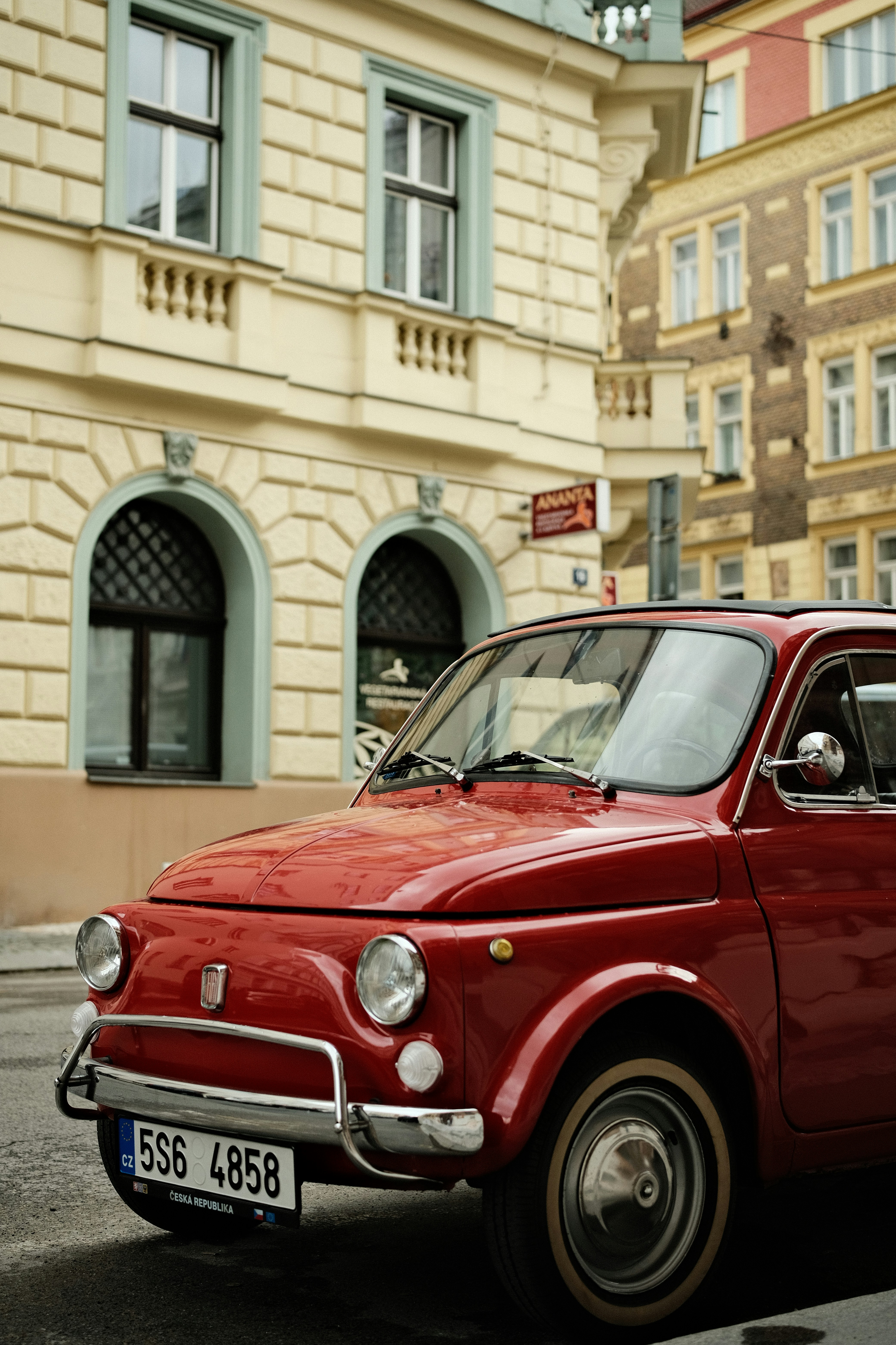 Fiat 500L | A vintage red fiat 500 parked on a street.